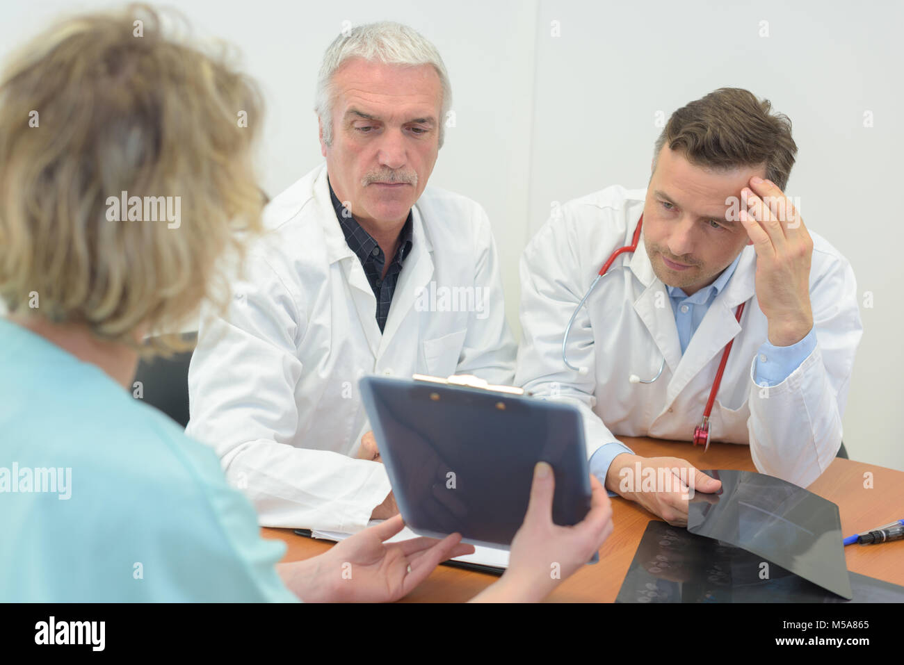 Medical workers comparing notes Stock Photo - Alamy