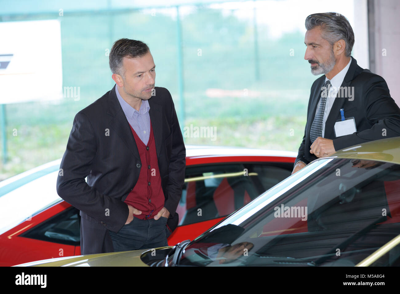 car dealer showing vehicle to potential customer Stock Photo - Alamy