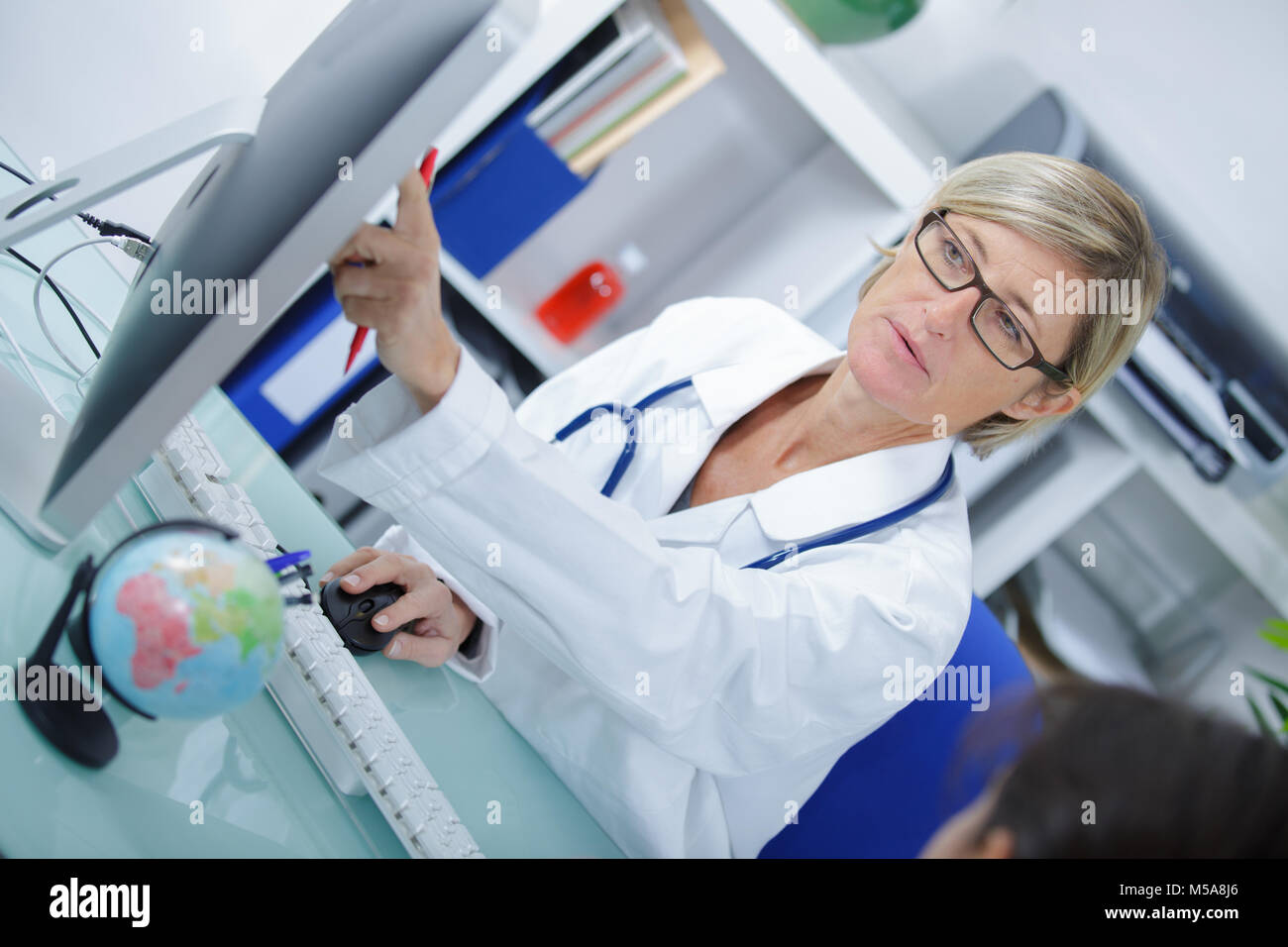 female doctor pointing to computer screen with surprised Stock Photo ...
