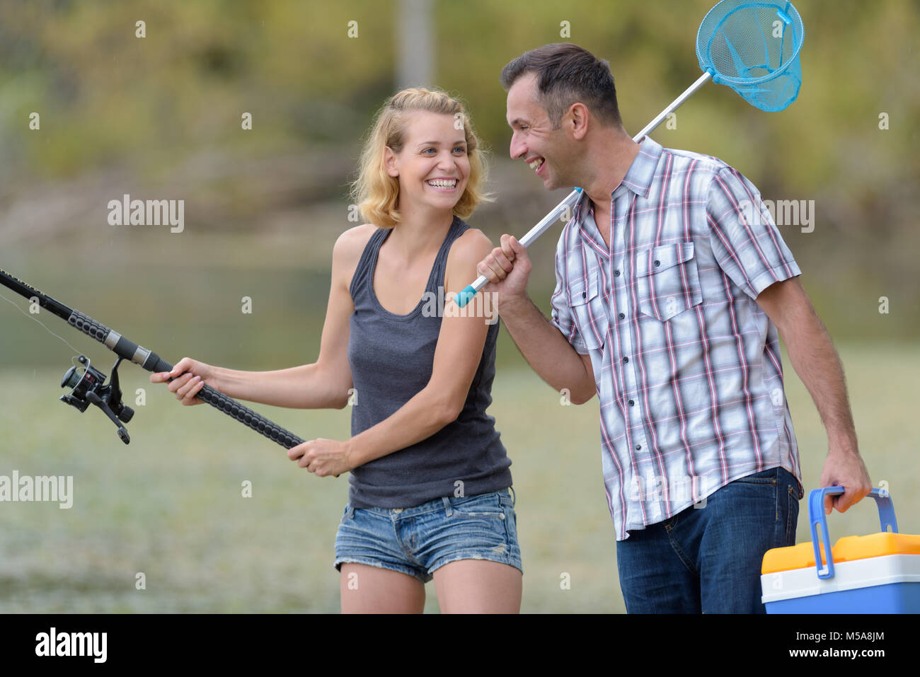 couple fishing on pier Stock Photo - Alamy