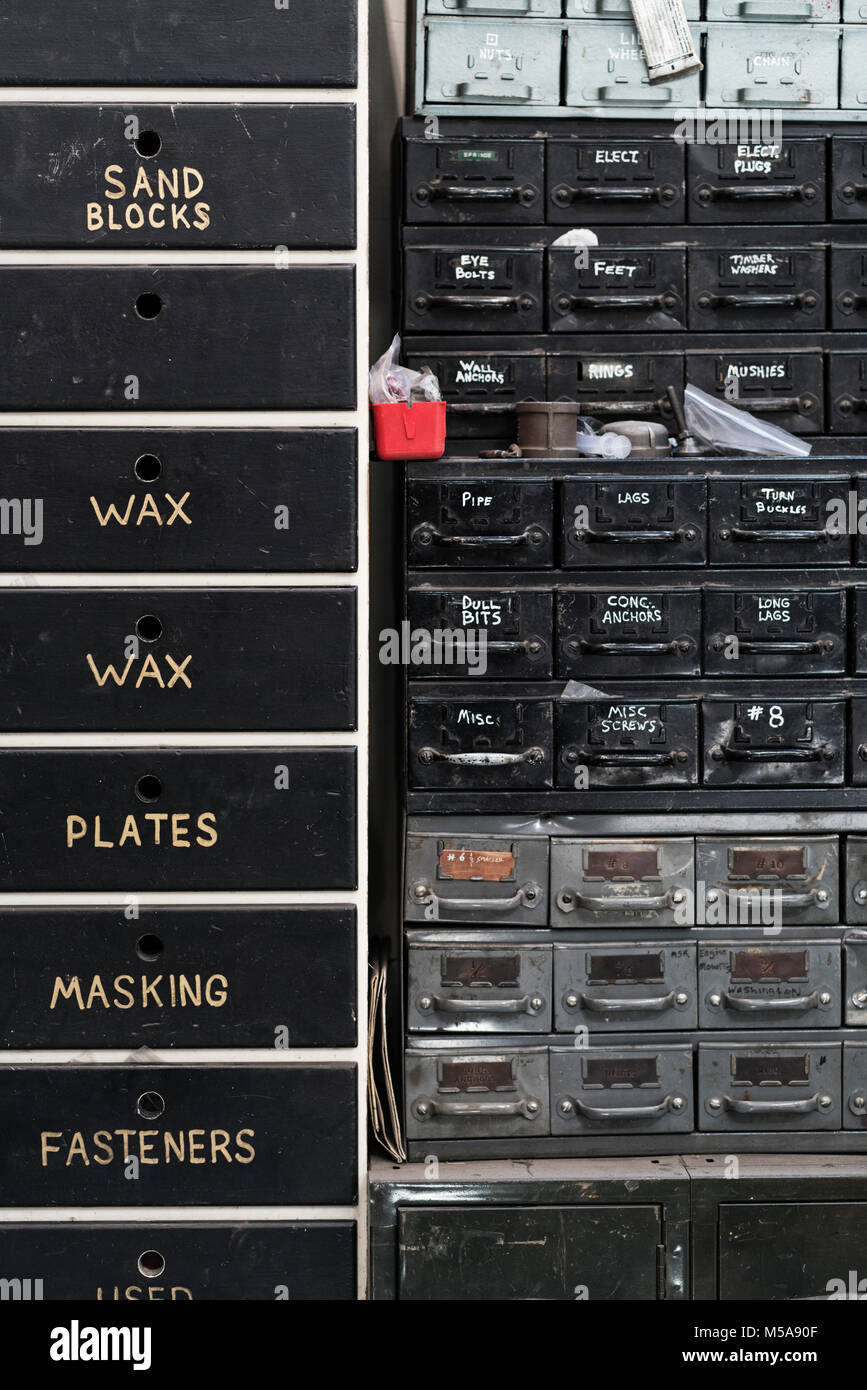 Close up of stack of metal drawers containing selection of hardware for ...