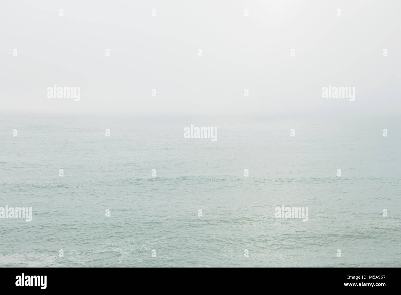 View across the ocean on a calm day, heavy fog in the air Stock Photo ...