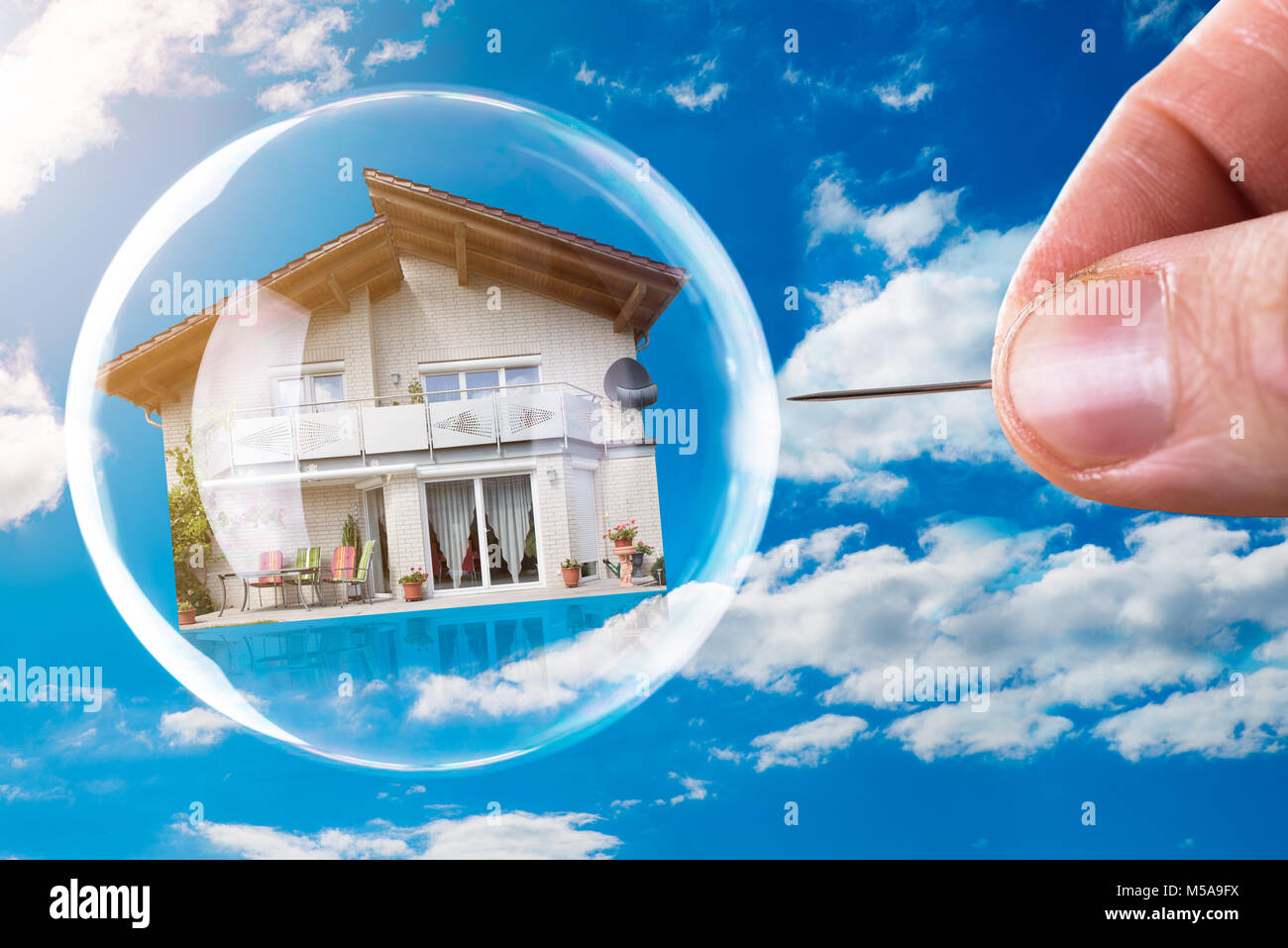 Human Hand Poking House And Bubble With Needle Against Cloudy Sky Stock ...