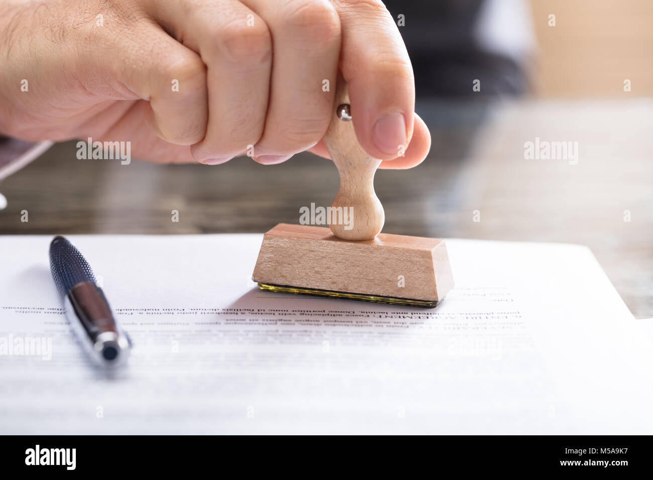 Close-up Of A Human Hand Stamping Document On Desk Stock Photo - Alamy