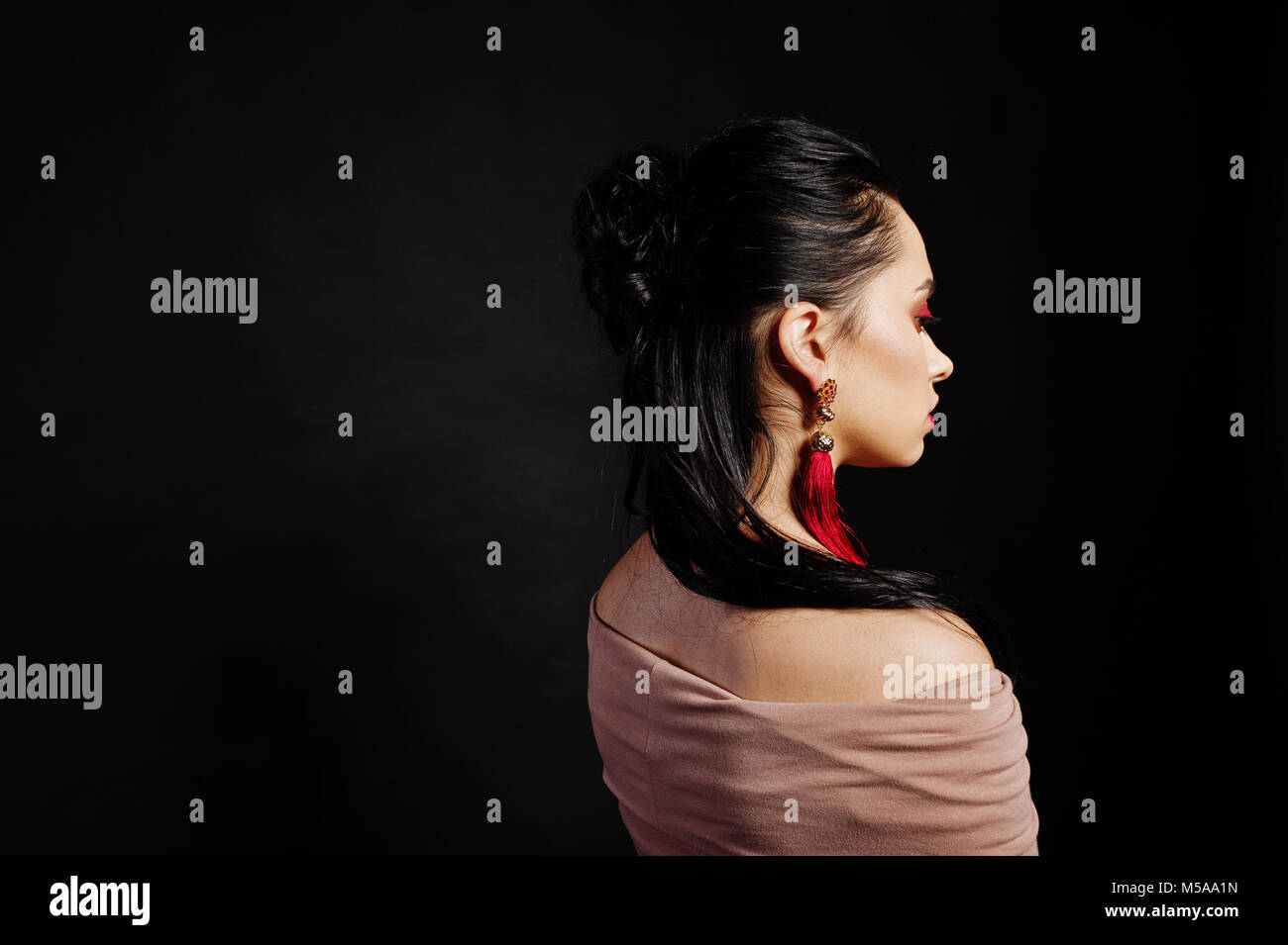 Studio portrait of back hairdress brunette girl on black background ...