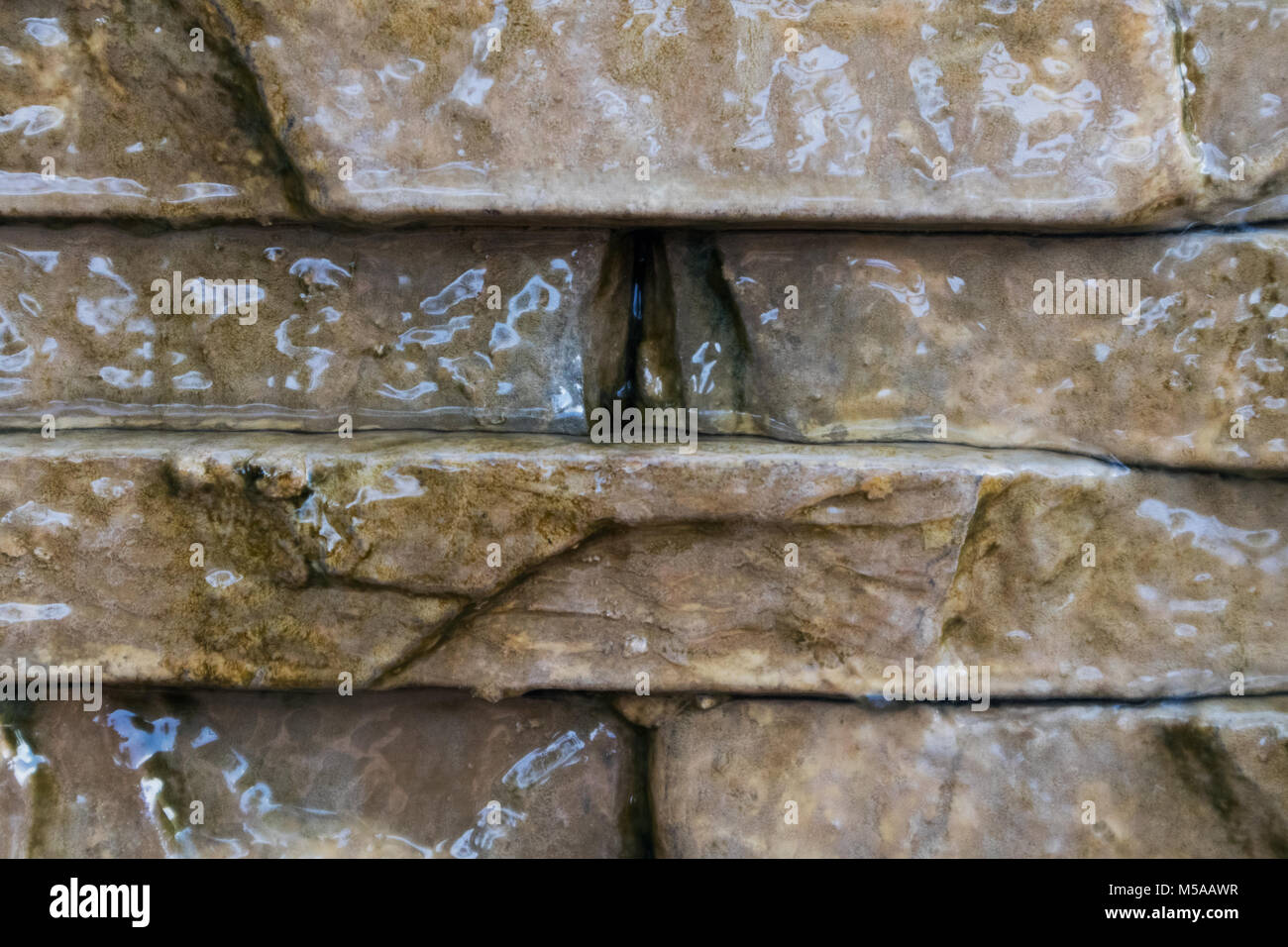 Stone wall with water running down Stock Photo - Alamy