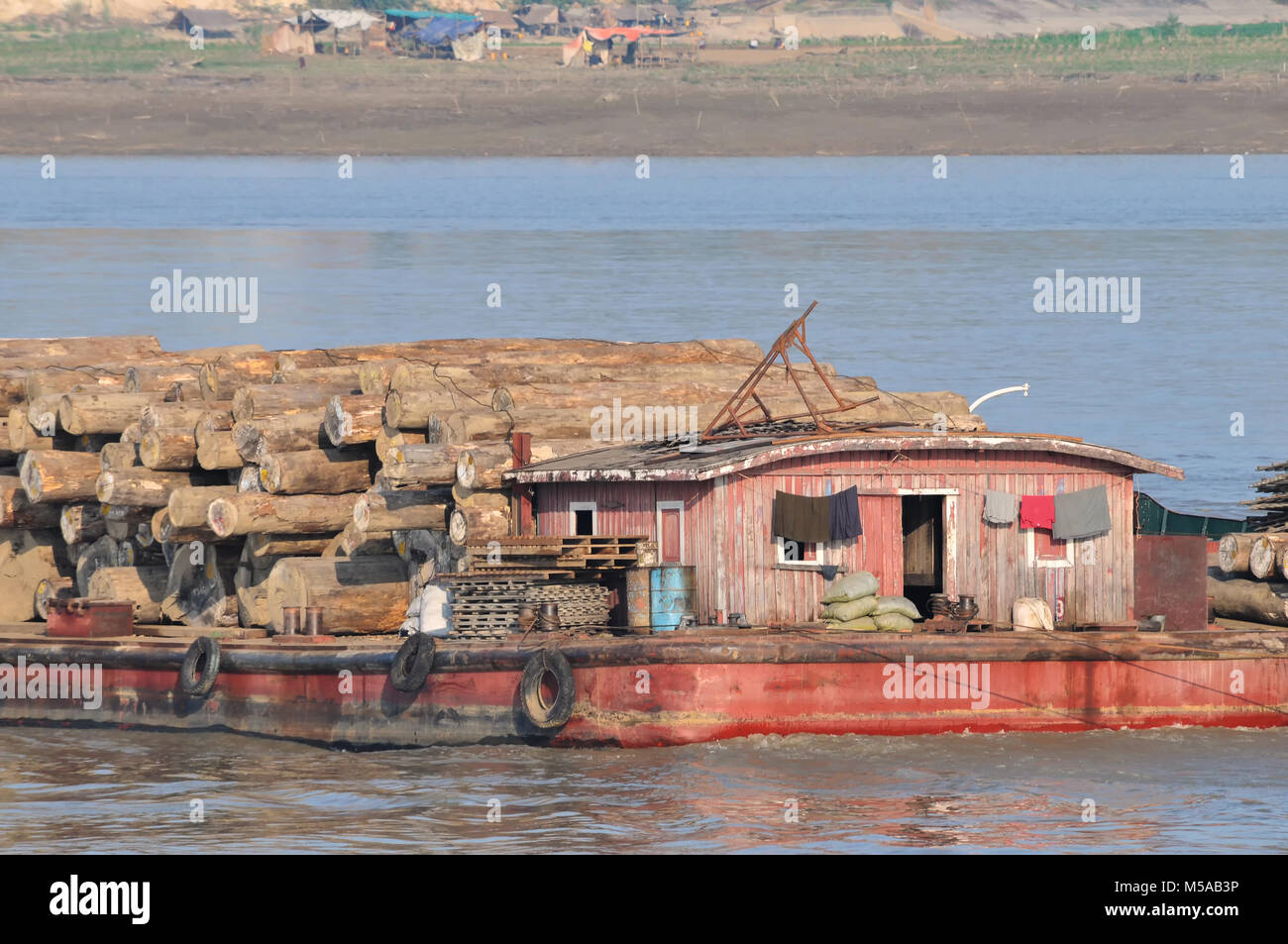 A view of the Irrawaddy River in Myanmar Burma with a large barge with ...