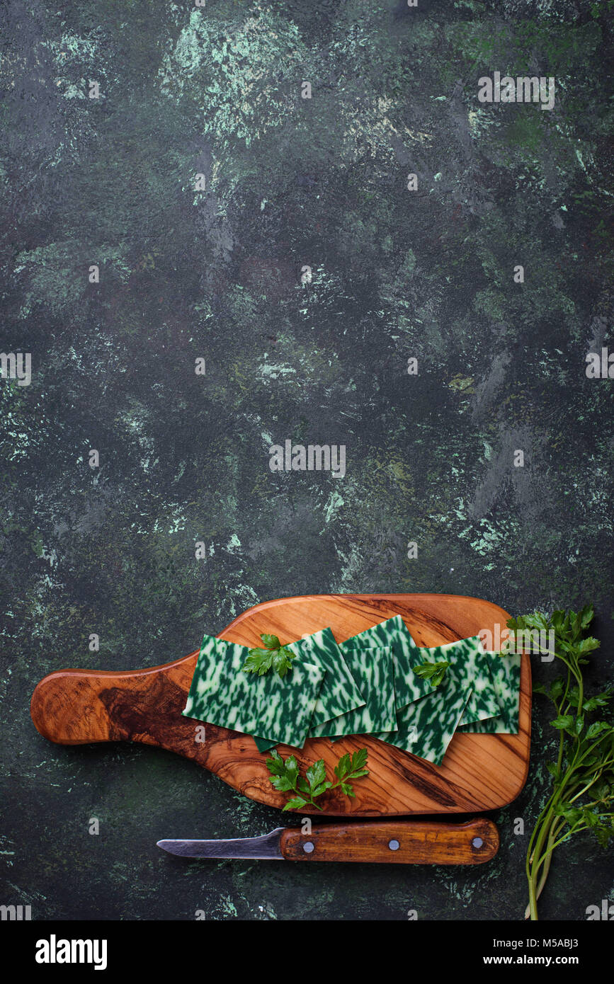Green sliced cheese with herbs Stock Photo - Alamy