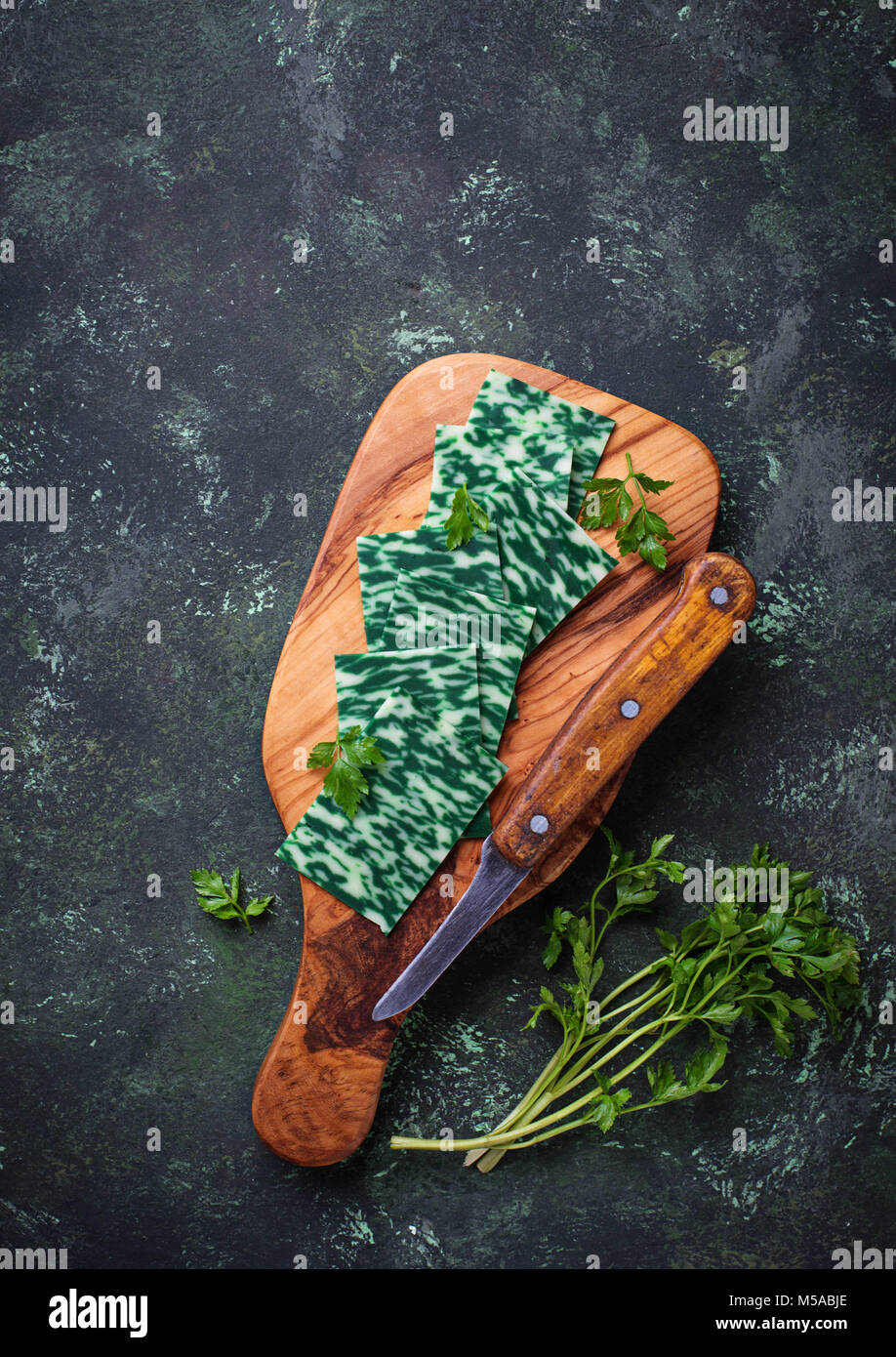 Green sliced cheese with herbs Stock Photo - Alamy