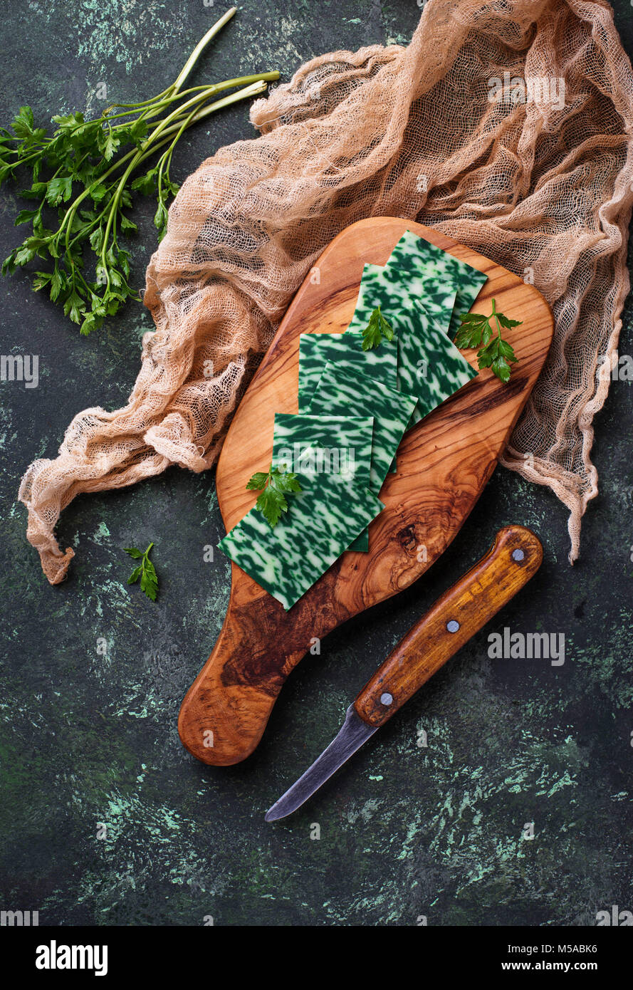 Green sliced cheese with herbs Stock Photo - Alamy