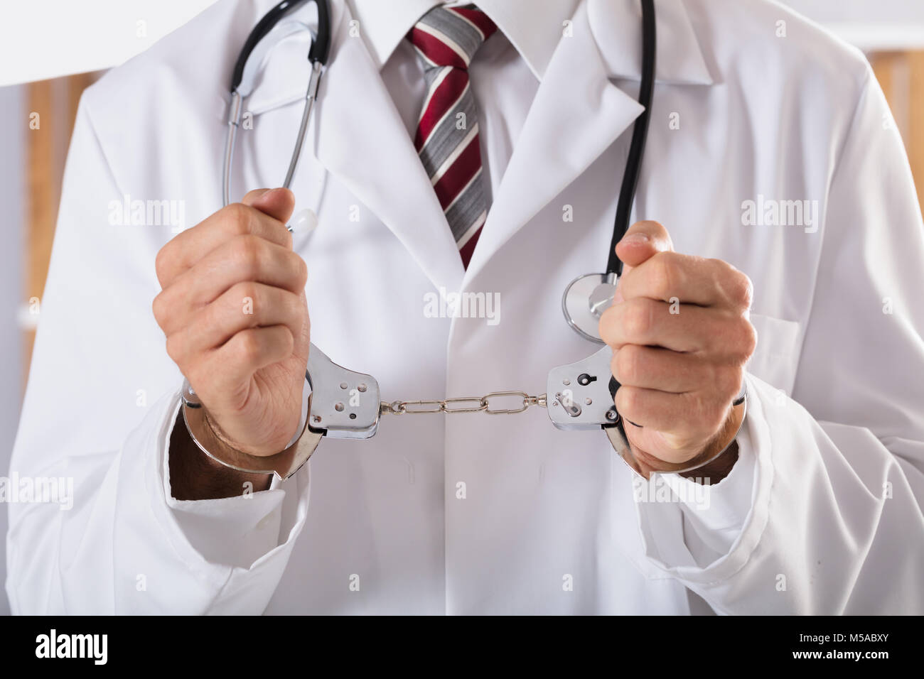 Close-up Of Arrested Doctor's Hand With Handcuffs Stock Photo - Alamy