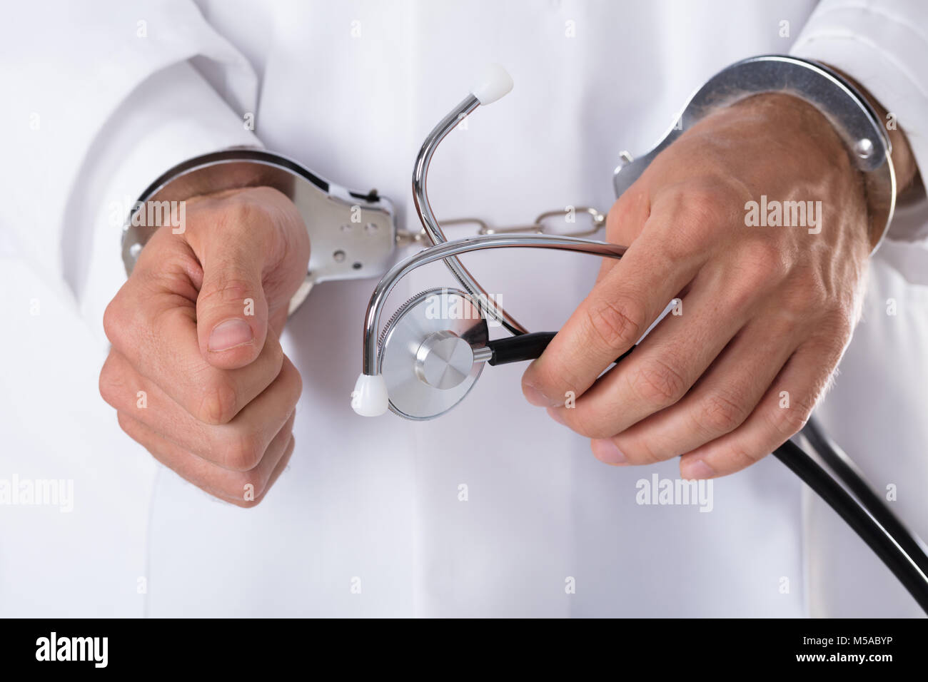Close-up Of Arrested Doctor's Hand With Handcuffs Holding Stethoscope ...