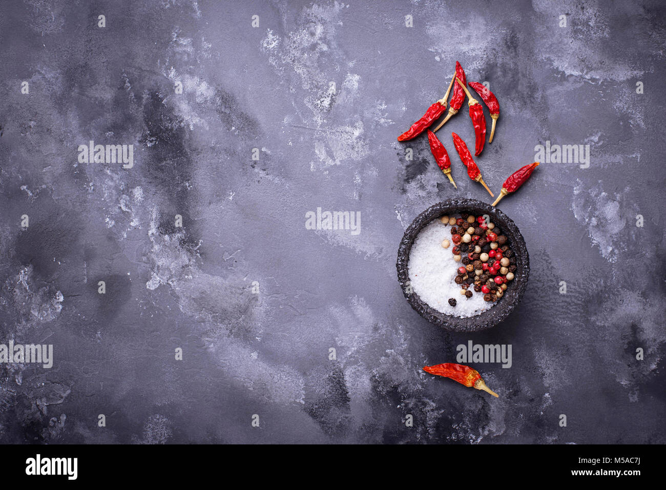 Mix of peppers and salt on gray background Stock Photo - Alamy