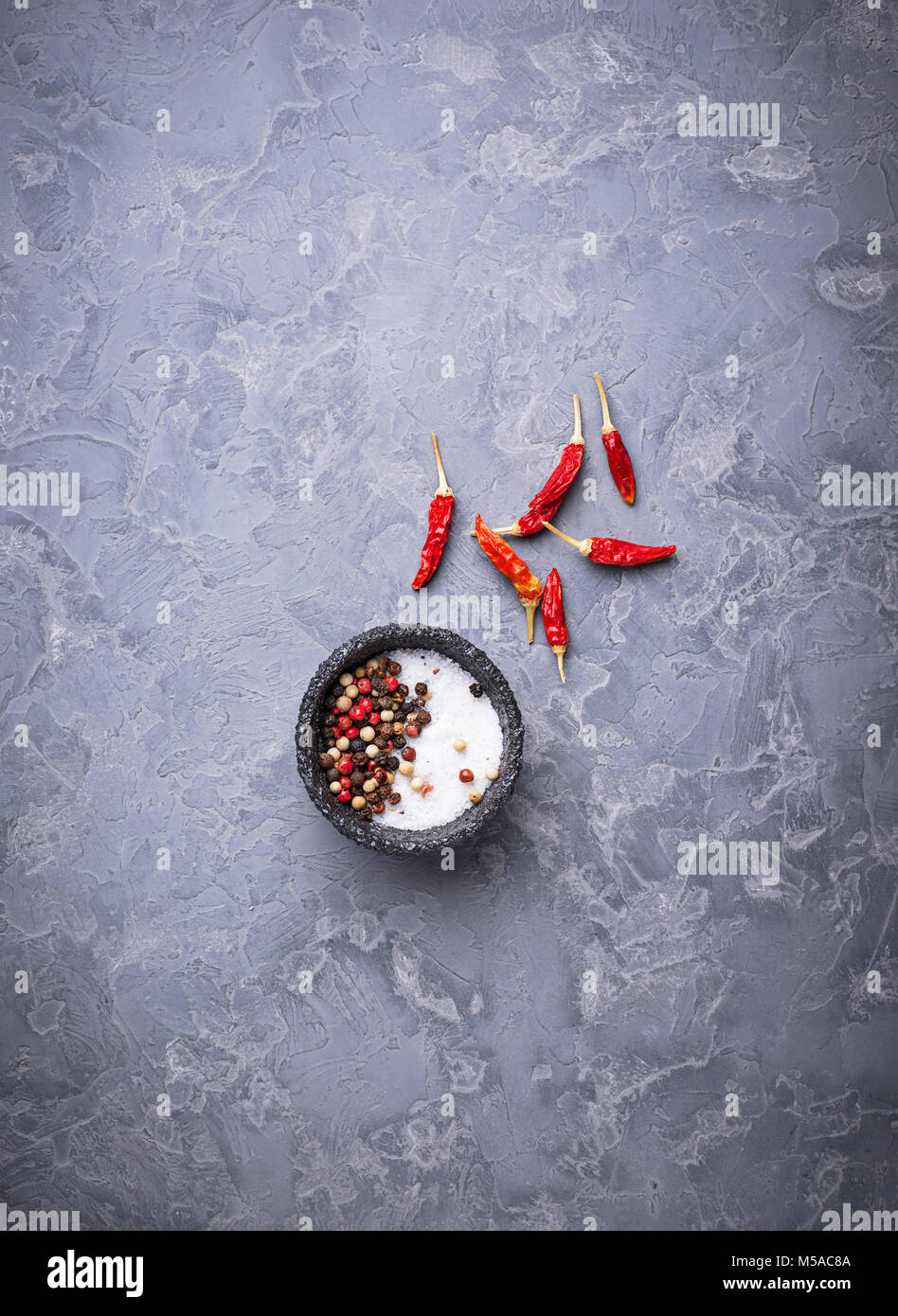 Mix of peppers and salt on gray background Stock Photo - Alamy