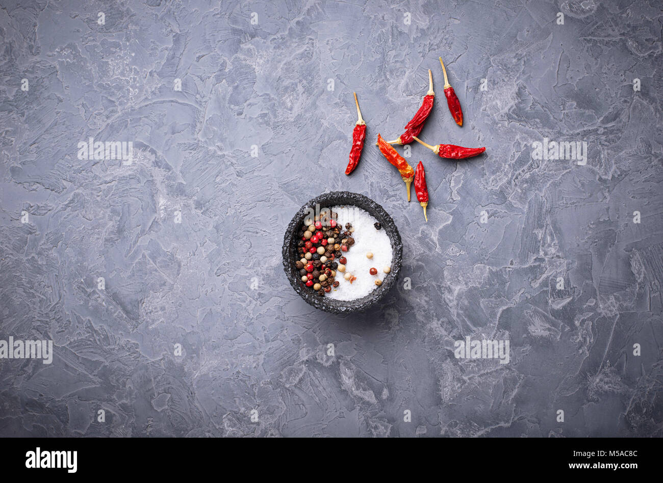 Mix of peppers and salt on gray background Stock Photo - Alamy