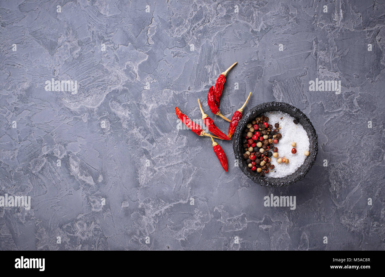 Mix of peppers and salt on gray background Stock Photo - Alamy