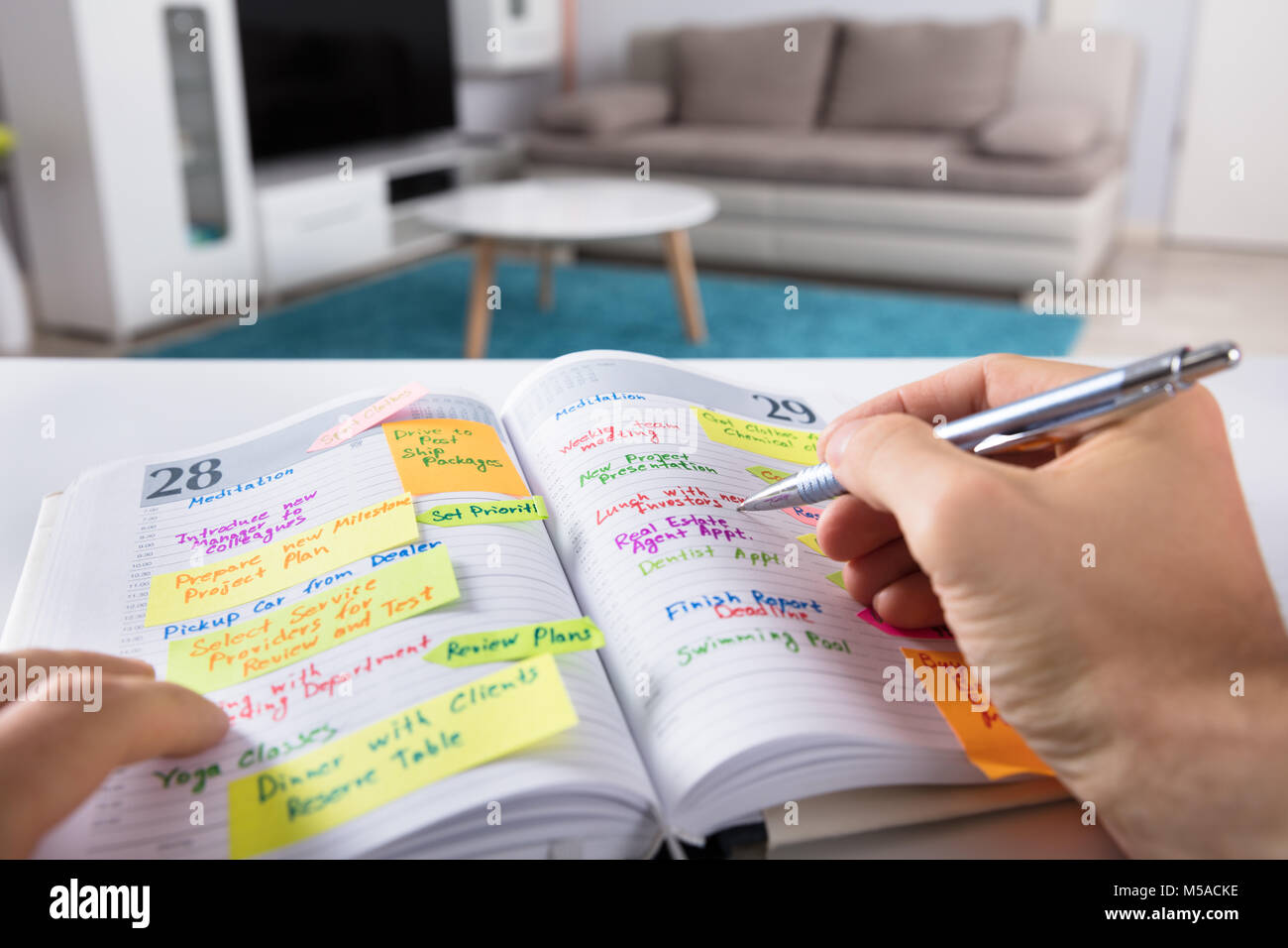 Close-up Of A Businessperson's Hand Writing Schedule In Diary With Pen ...
