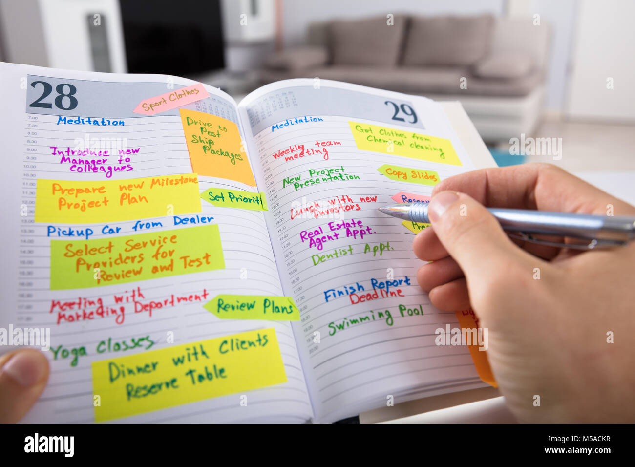 Close-up Of A Businessperson's Hand Writing Schedule In Diary With Pen ...