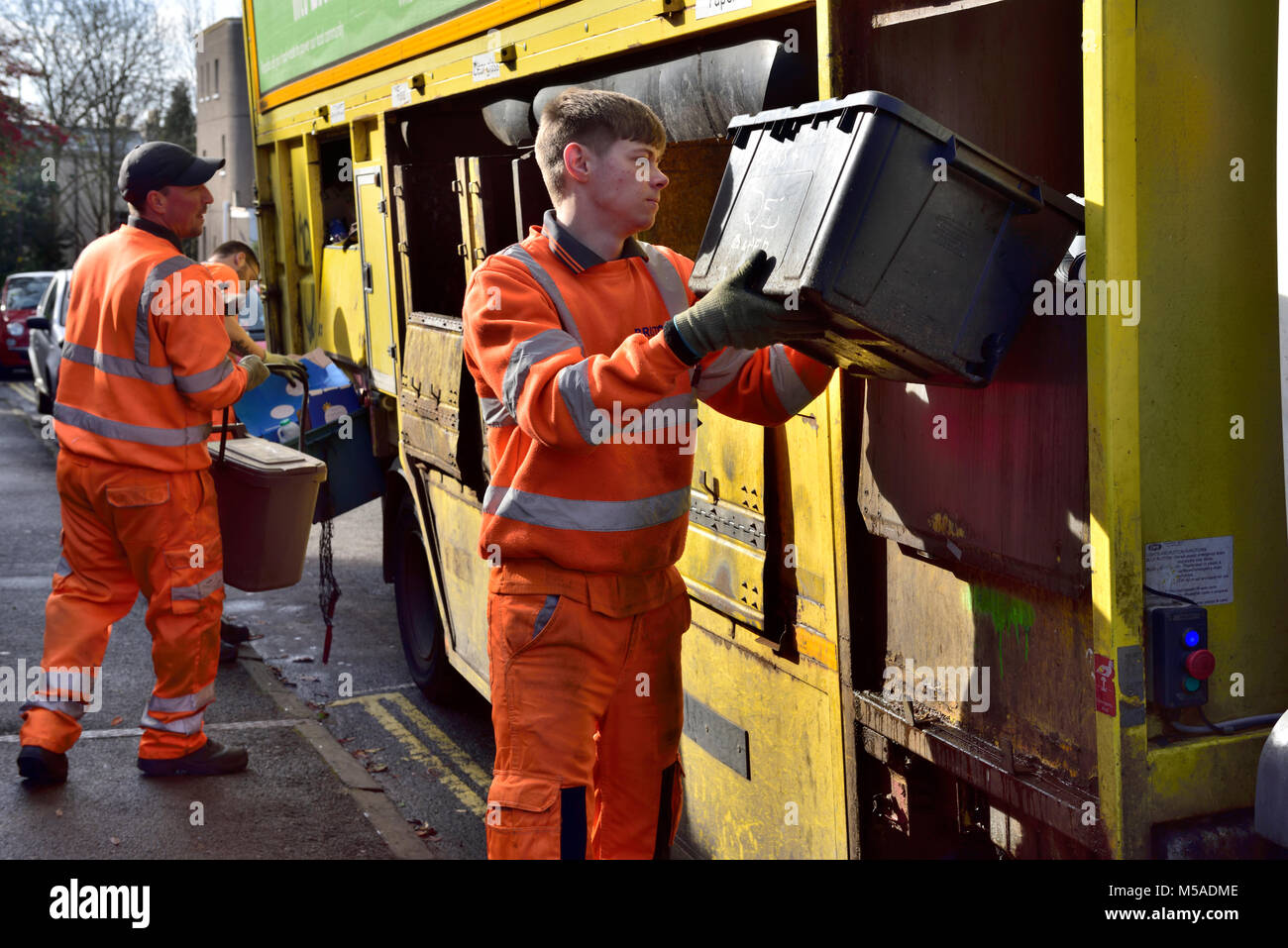 Recycling collection lorry with workmen on rounds doing sorting as they ...