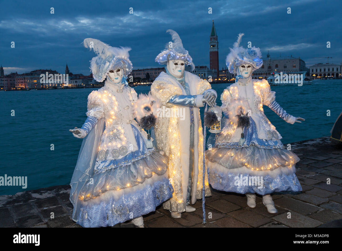 Venice Carnival costumes at night, Venice, Veneto, Italy. Three people ...
