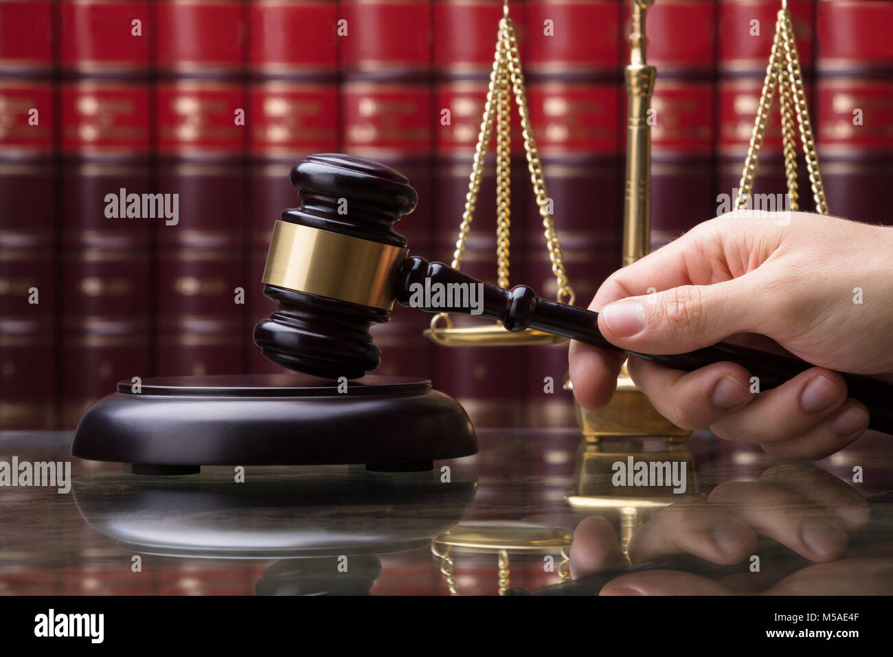 Close-up Of A Human Hand Striking Mallet In Front Of Golden Weighing ...