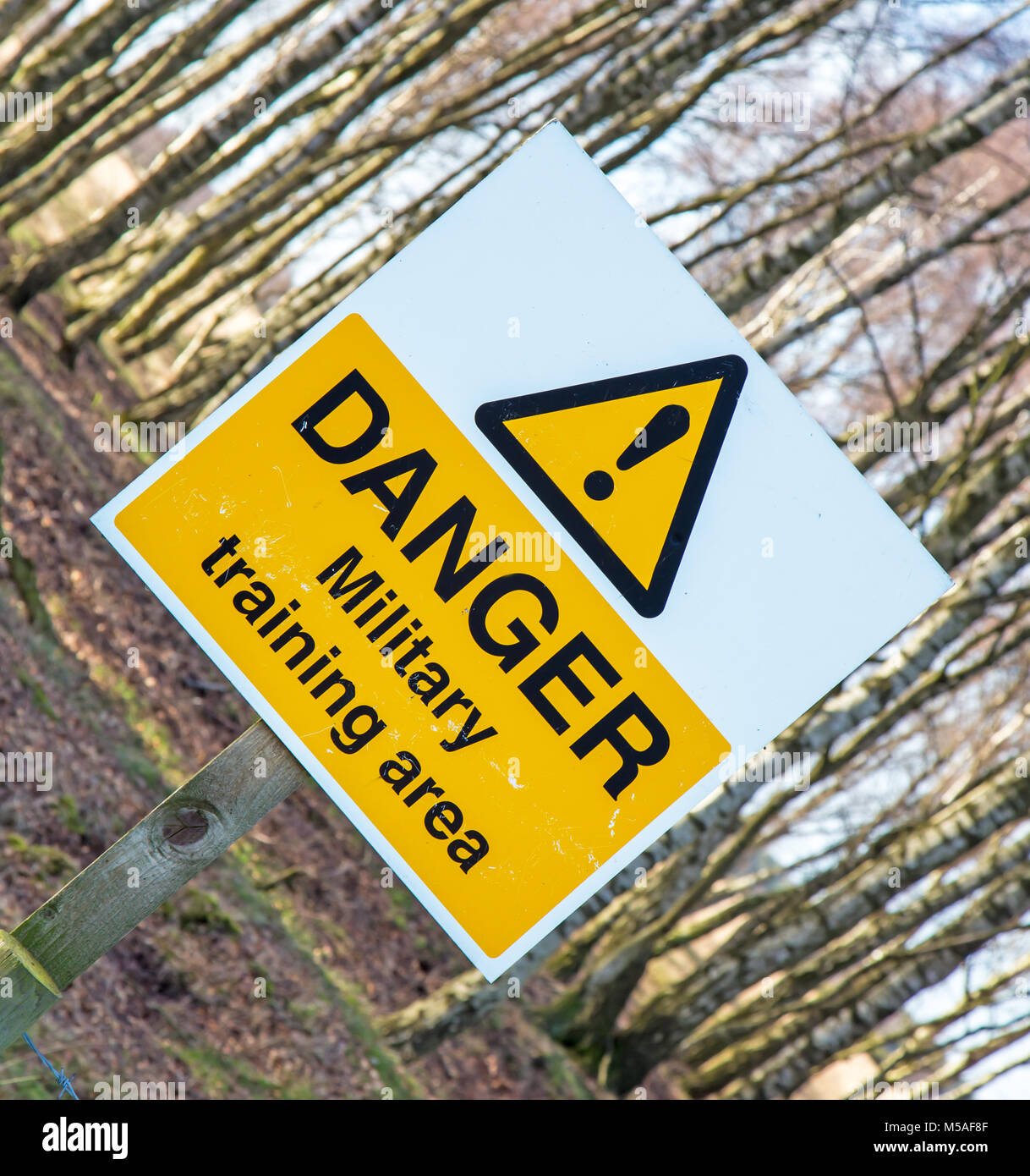 Sign warning of troops training in the area, set in woodland Stock ...