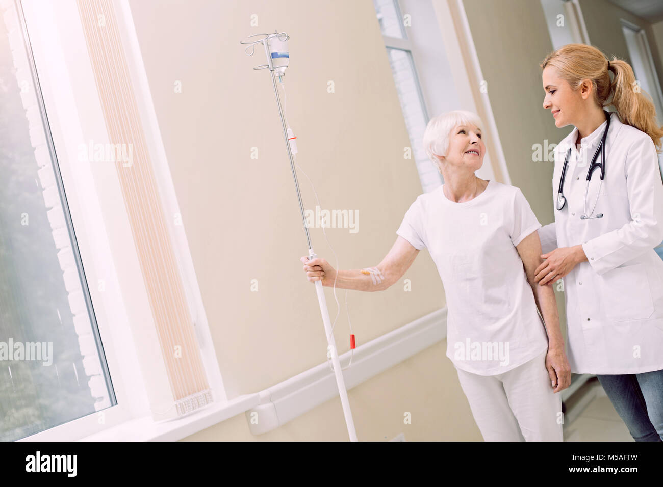 Doctor helping senior patient with drop counter Stock Photo - Alamy