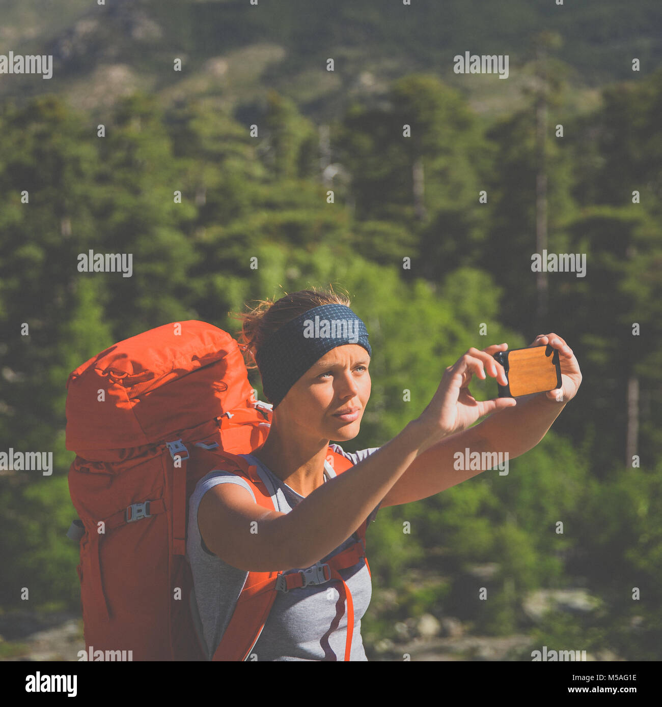 Pretty, female hiker in high mountains packing her backpack Stock Photo ...