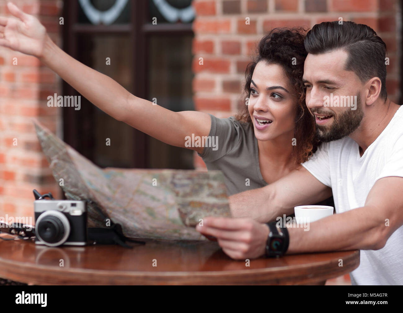 Young tourists having coffee at cafe and reading map Stock Photo - Alamy
