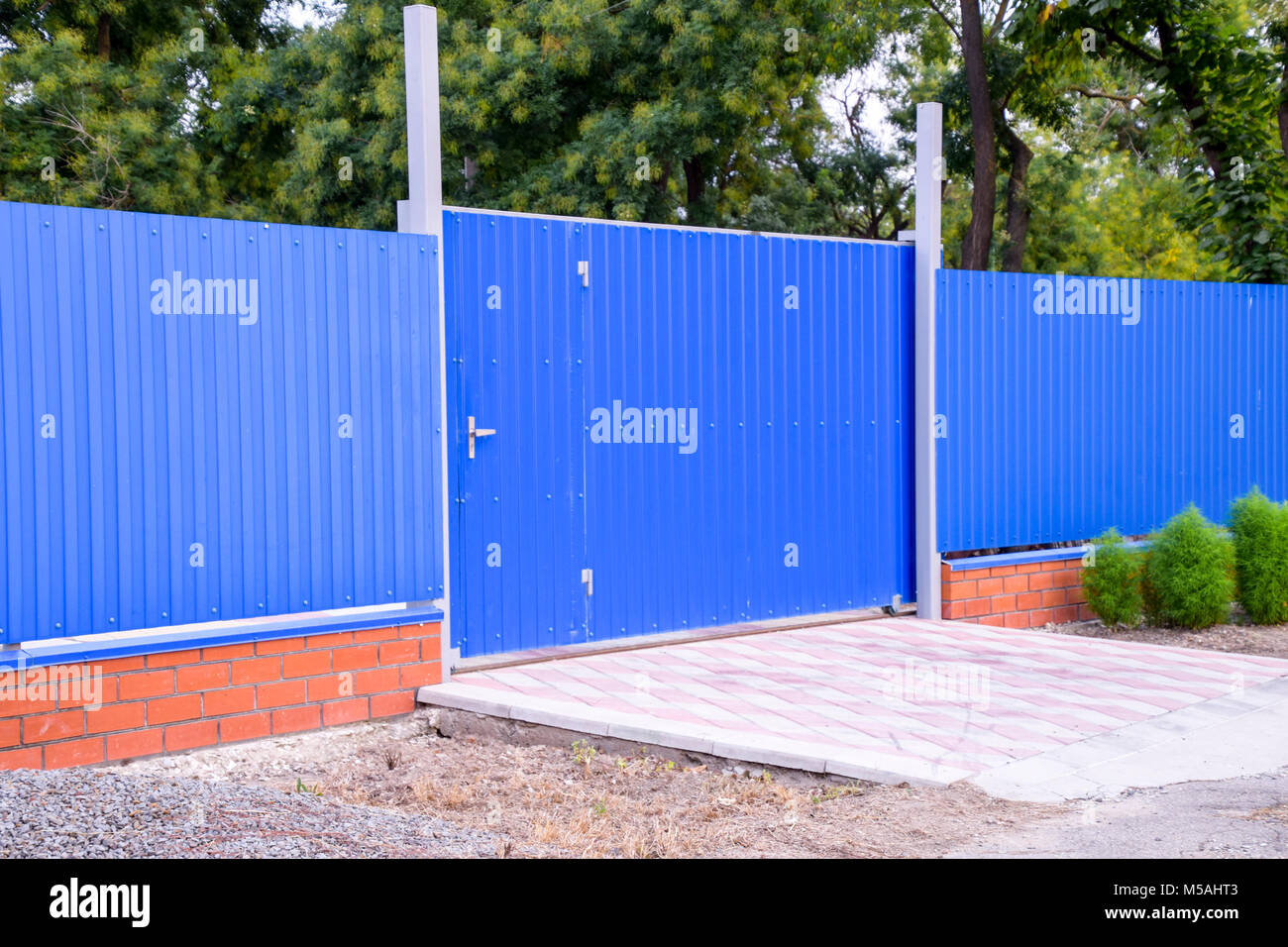 Fence and gate from sheets of blue corrugated metal Stock Photo - Alamy