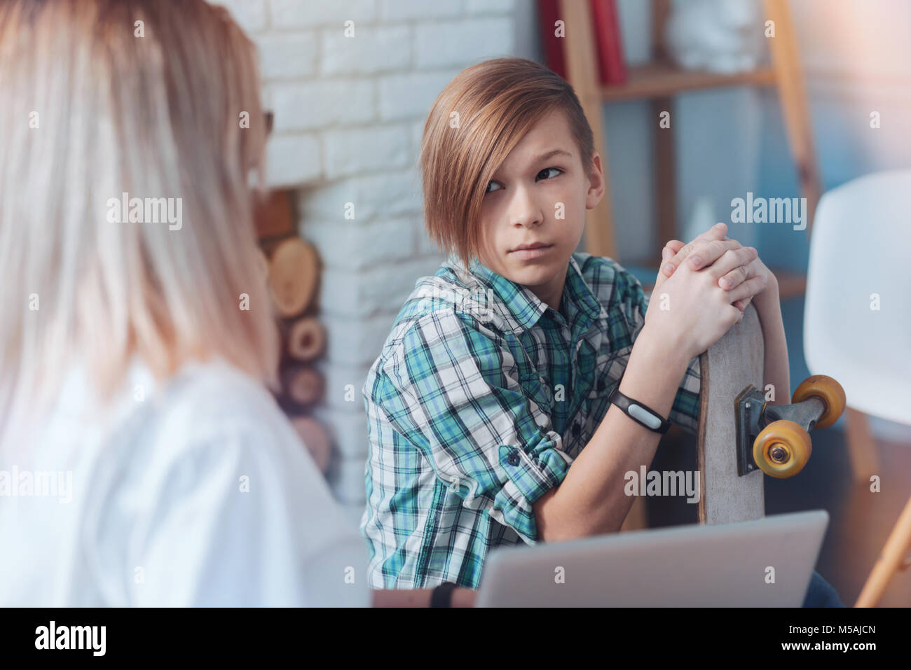 Problem boy looking at psychologist with distrust Stock Photo - Alamy