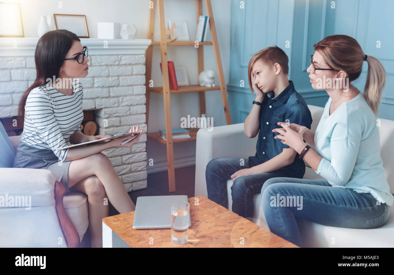 Serious young psychologist listening to mother of troublesome teenage ...