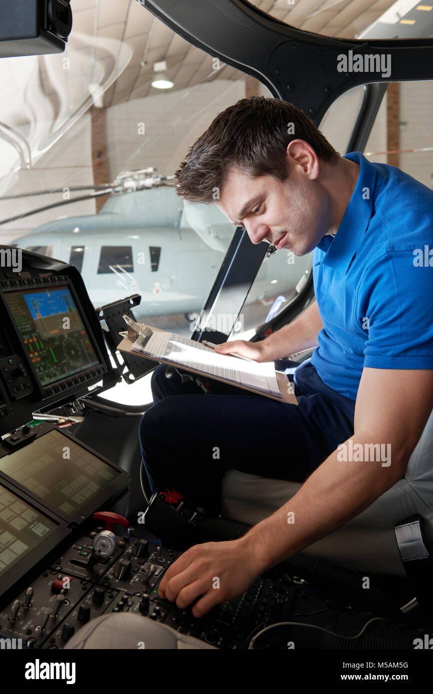 Male Aero Engineer With Clipboard Working In Helicopter Cockpit Stock ...
