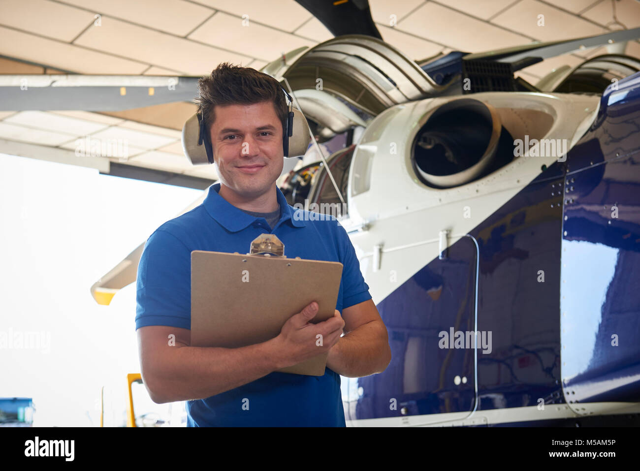 Portrait Of Male Aero Engineer With Clipboard Carrying Out Check On ...