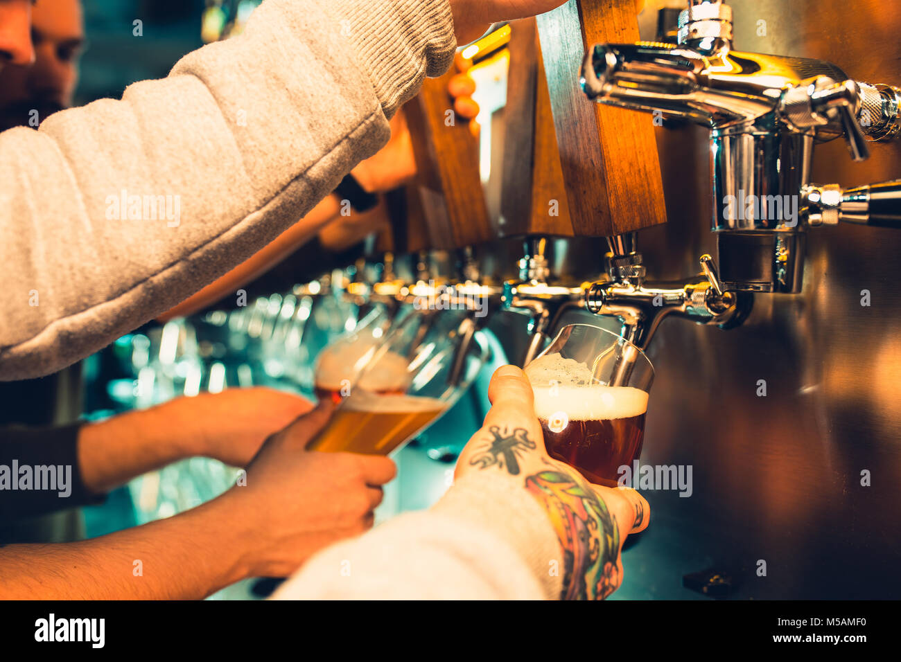 Hand of bartender pouring a large lager beer in tap Stock Photo - Alamy