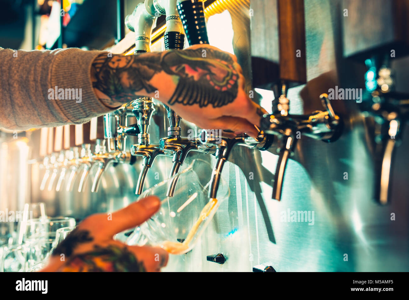 Hand of bartender pouring a large lager beer in tap Stock Photo - Alamy