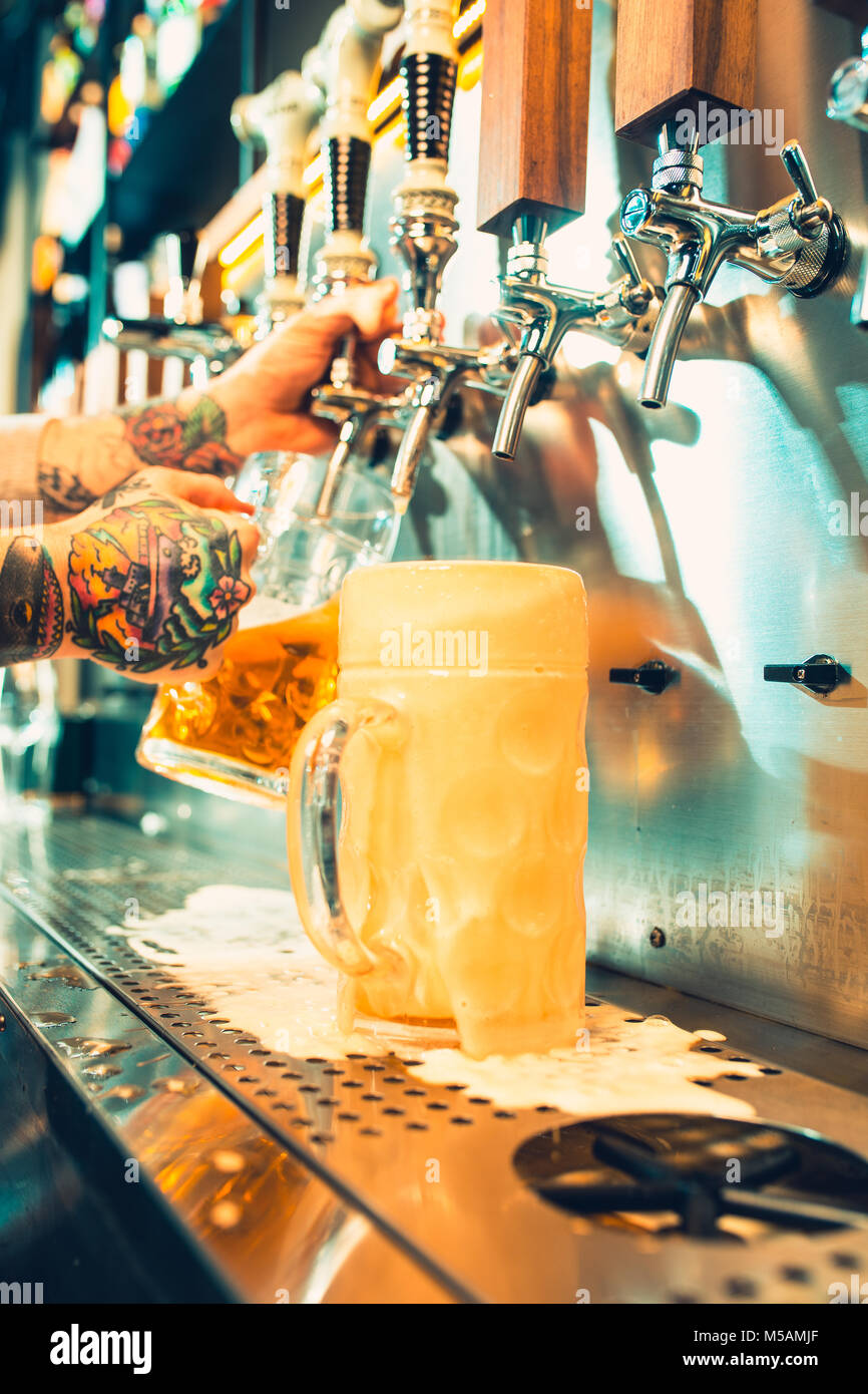 Hand of bartender pouring a large lager beer in tap Stock Photo - Alamy