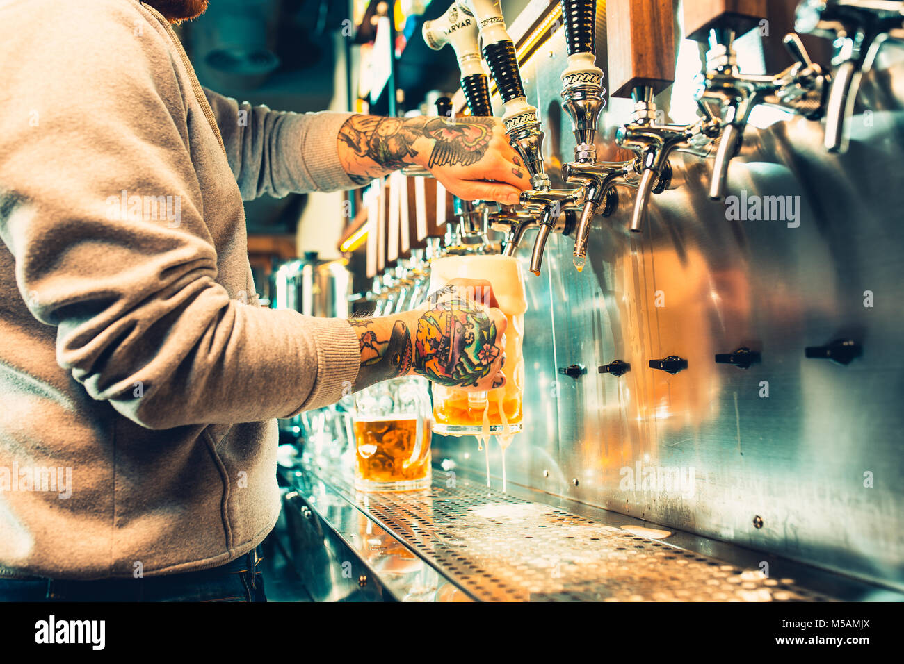 Hand of bartender pouring a large lager beer in tap Stock Photo - Alamy