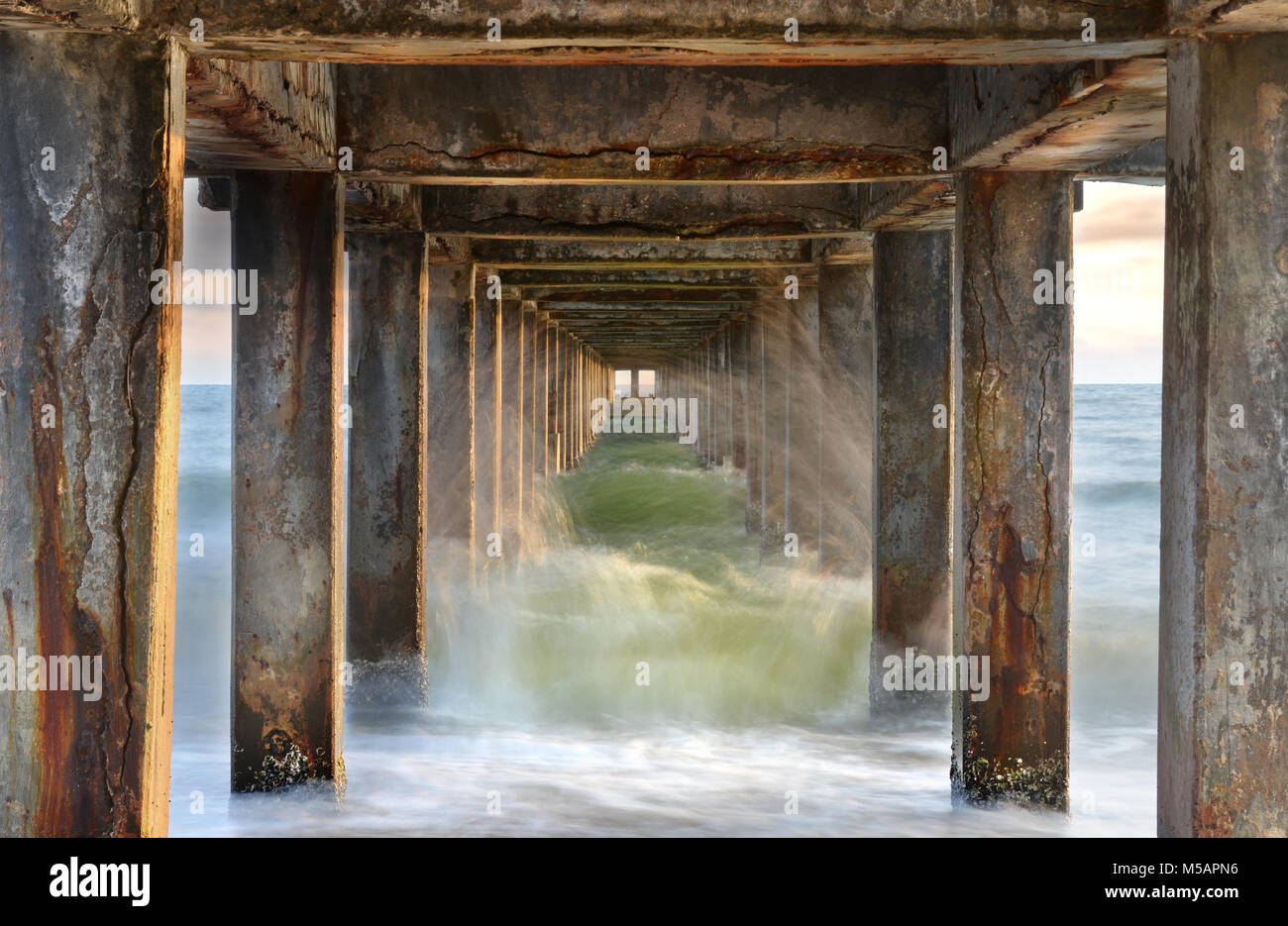 Under old concrete bridge on the beach to the sea photo in sunset low ...