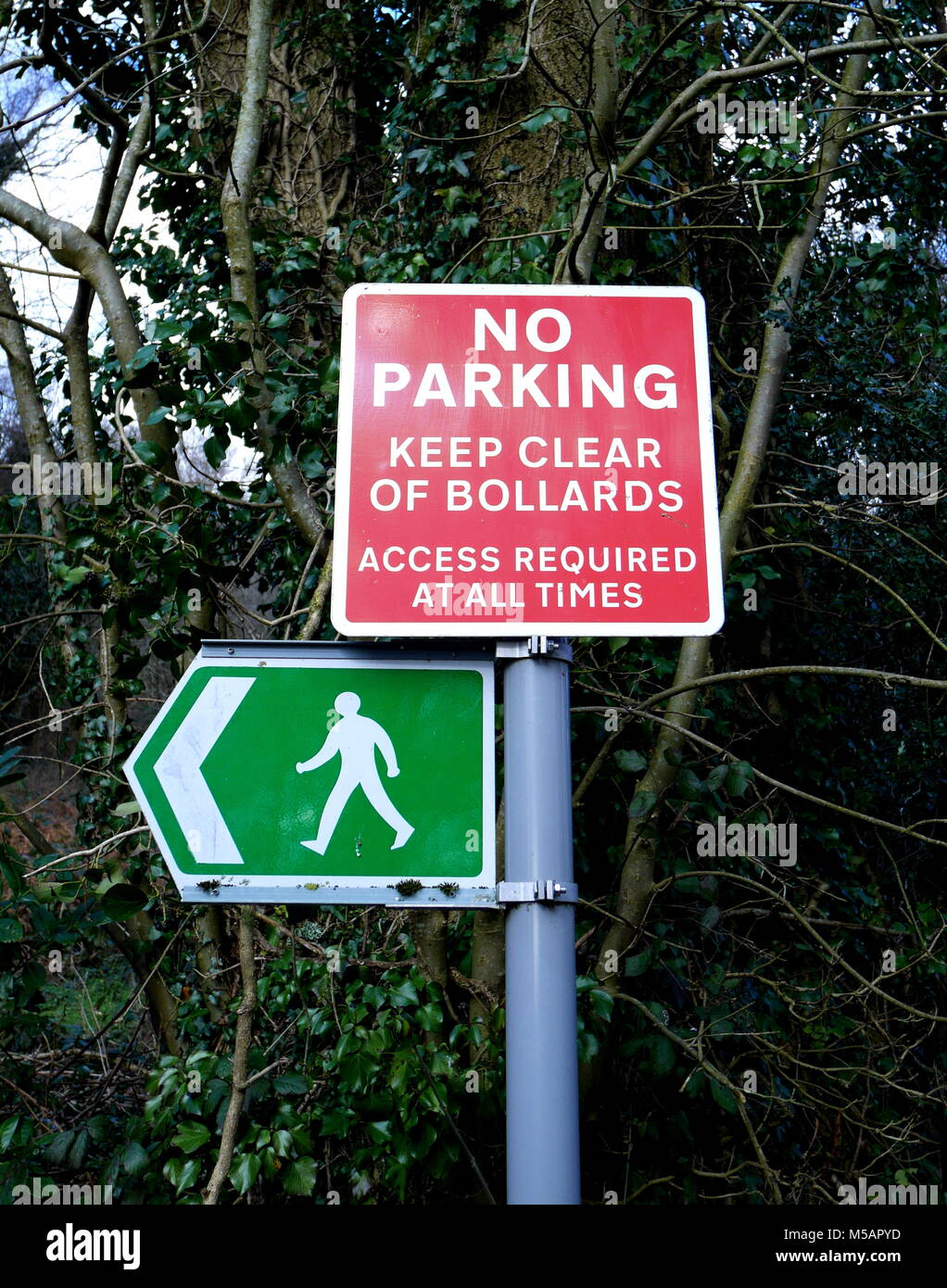 Road sign indicating footpath, no parking, keep clear of bollards ...
