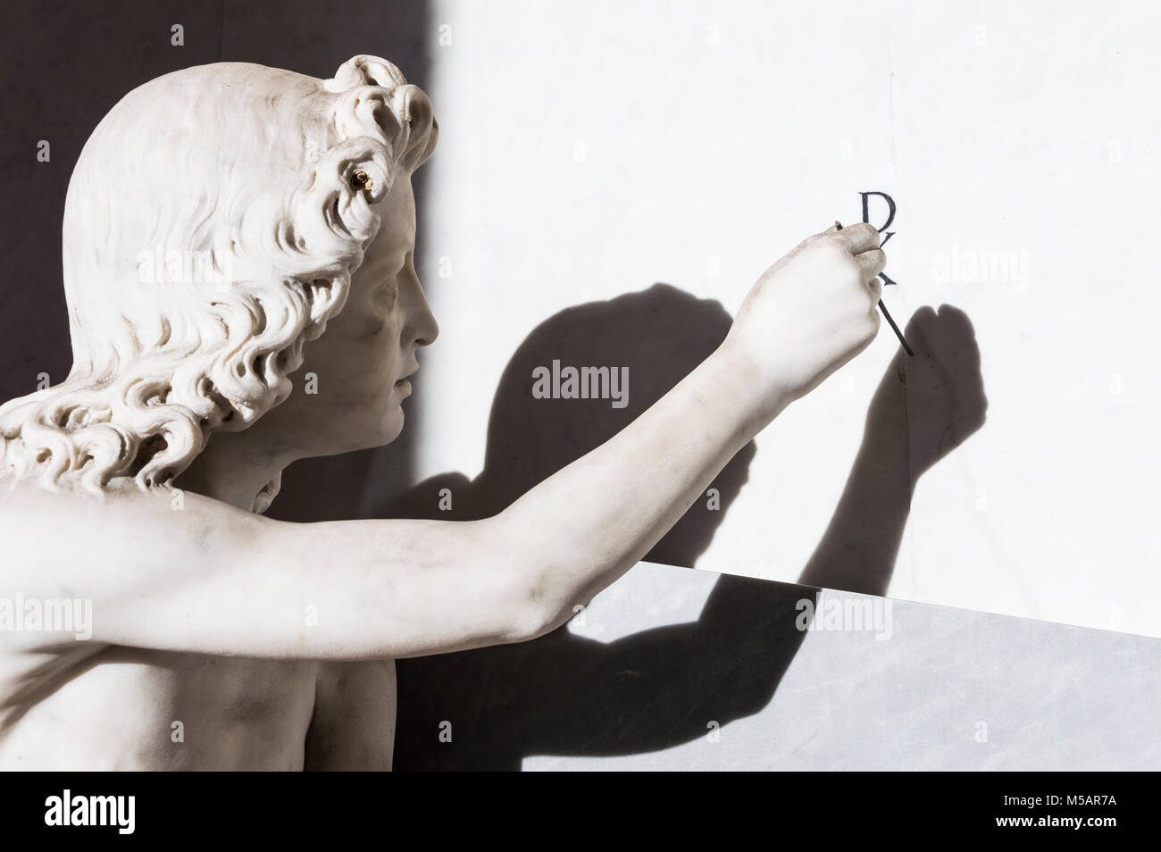 Statue of an Angel writing letter "P" of Peace Stock Photo - Alamy
