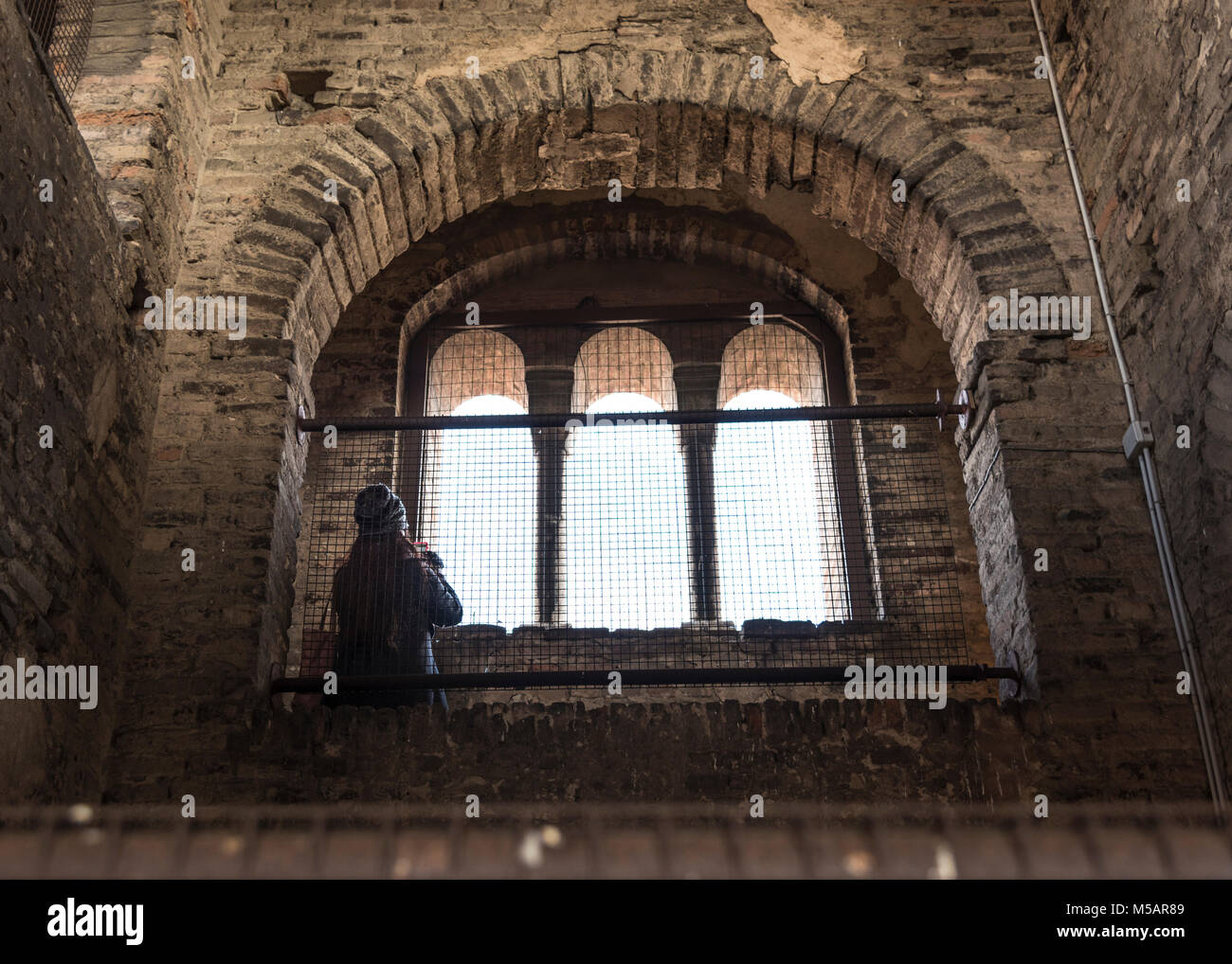 Europe travel woman looking throught big window of and old medieval ...