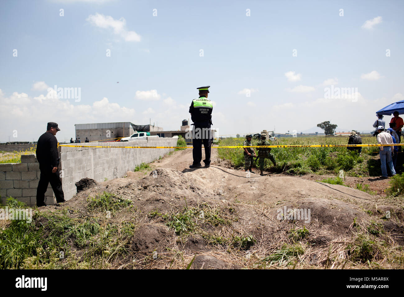 A police officer guards a small farm house that was used by Joaquin "El Chapo" Guzman to escape ...