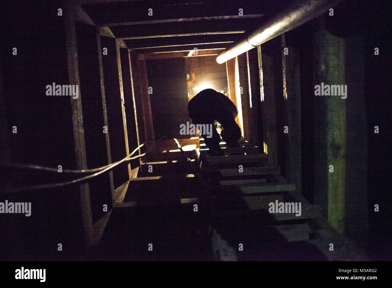 A media member crawls out of the farm house tunnel used by Joaquin "El Chapo" Guzman to escape ...