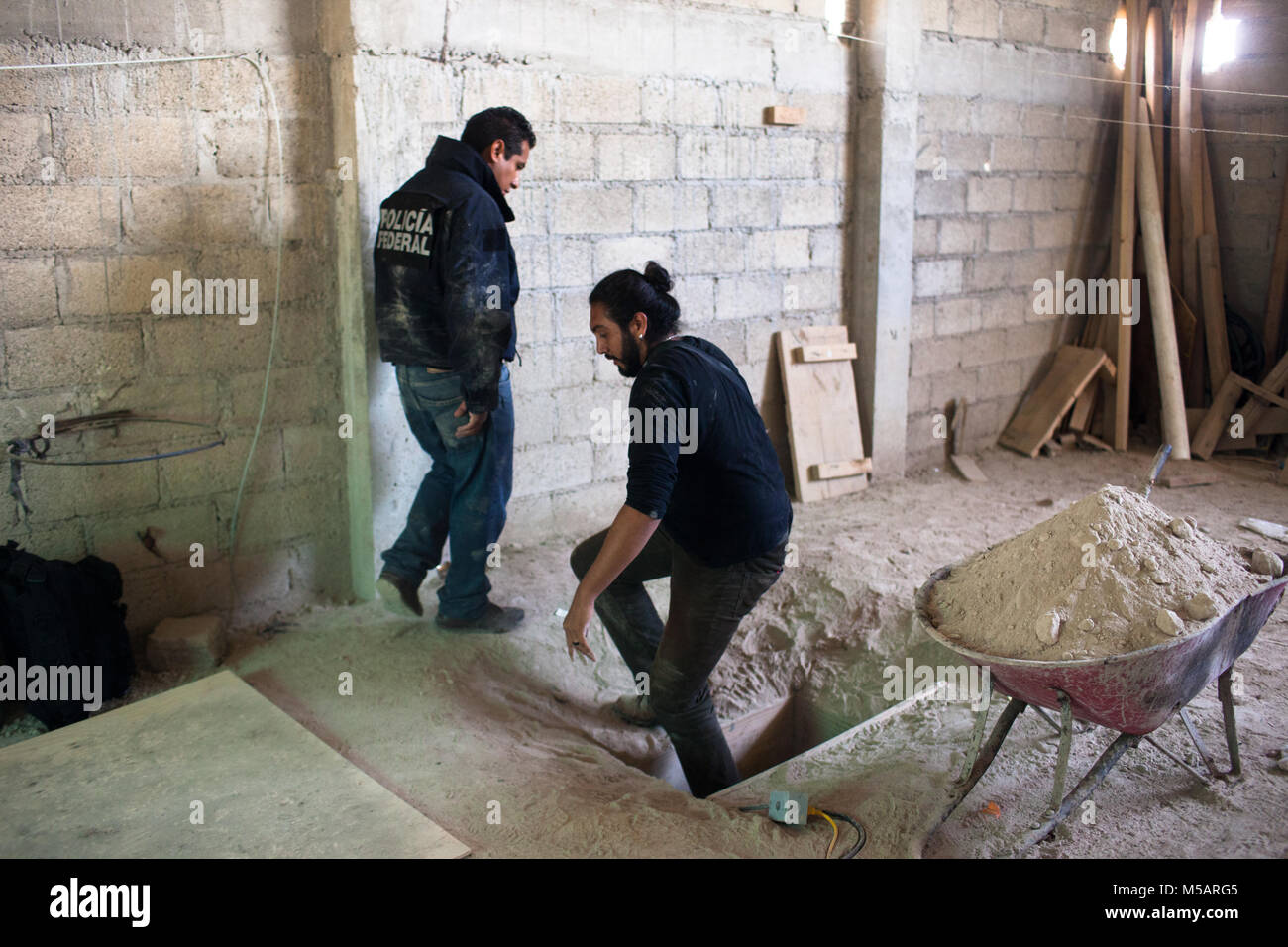 A media member crawls out of the farm house tunnel used by Joaquin "El Chapo" Guzman to escape ...