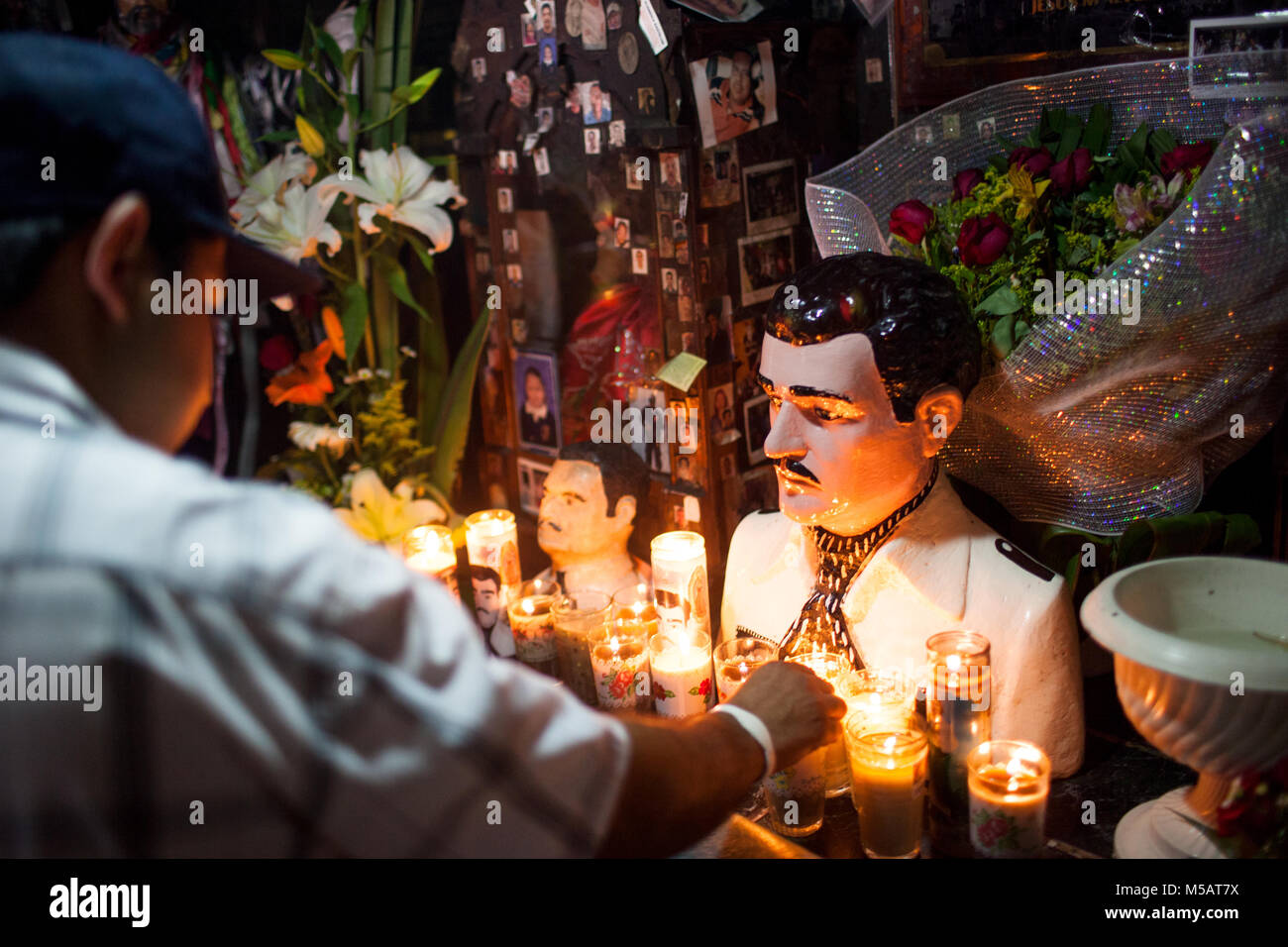 A man lights a candle in the shrine of Jesœs Malverde in Culiac‡n ...