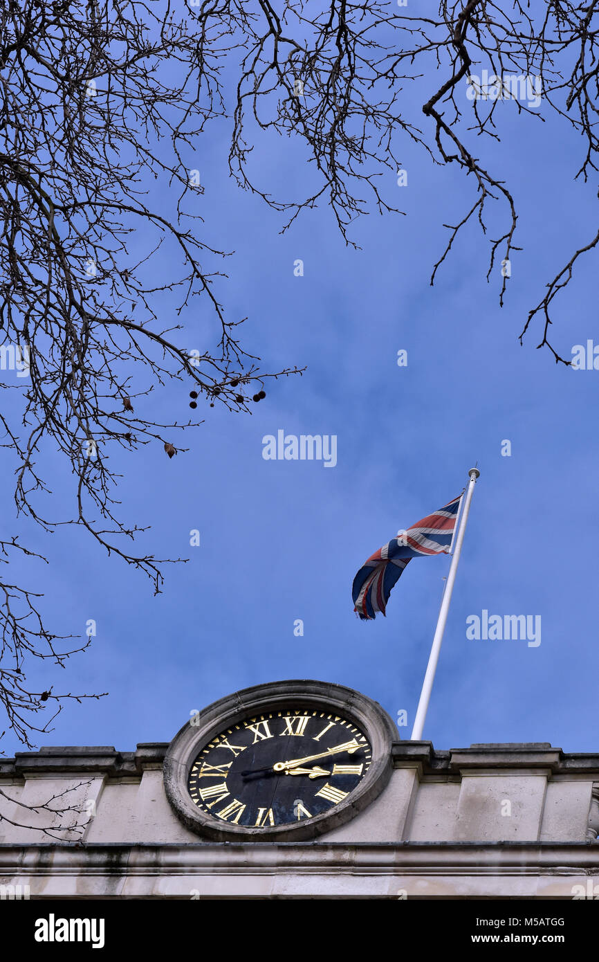 An old clock and the union flag flying above an historic building in ...