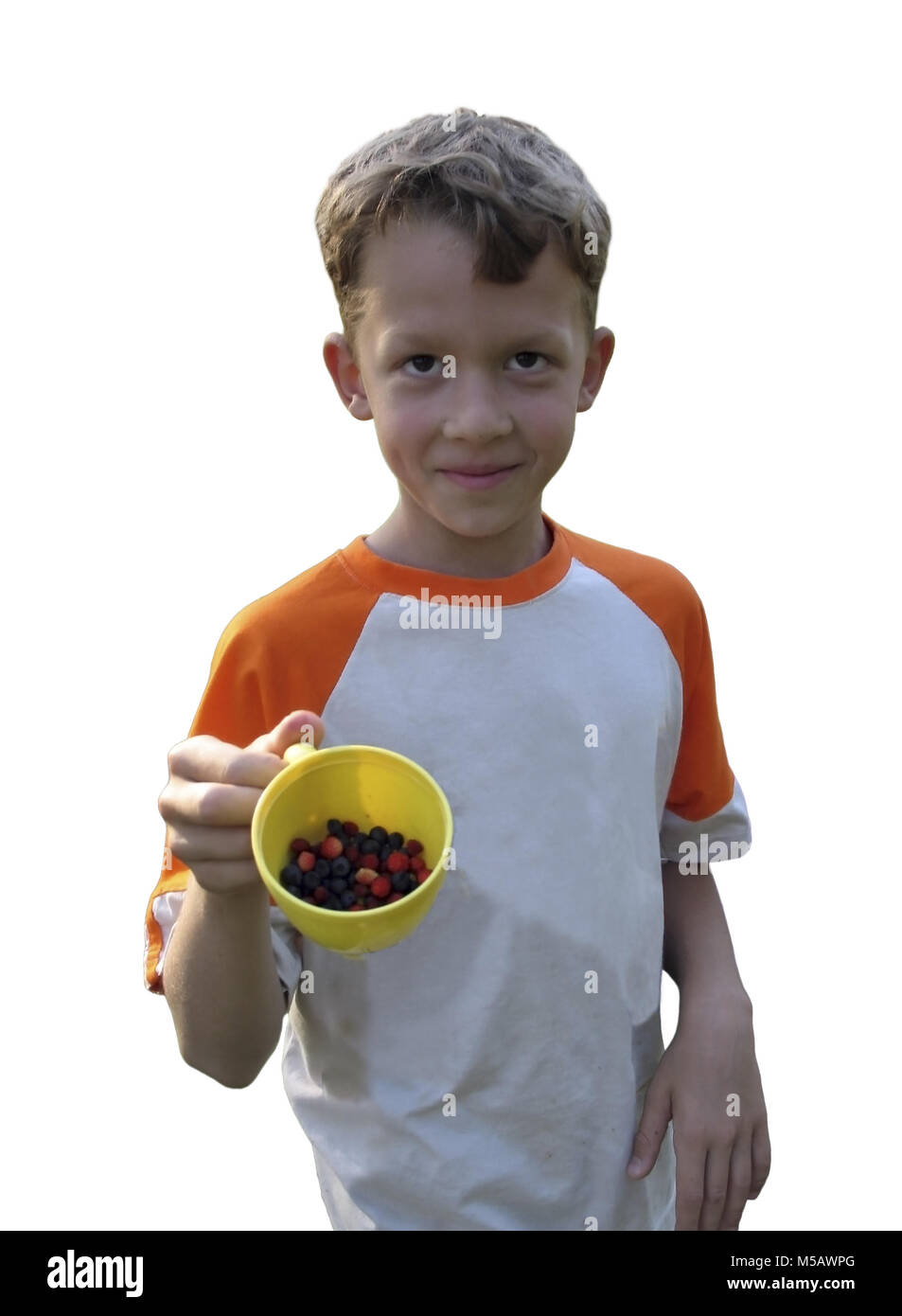Little cute boy showing a cup with berries gathered in the forest ...