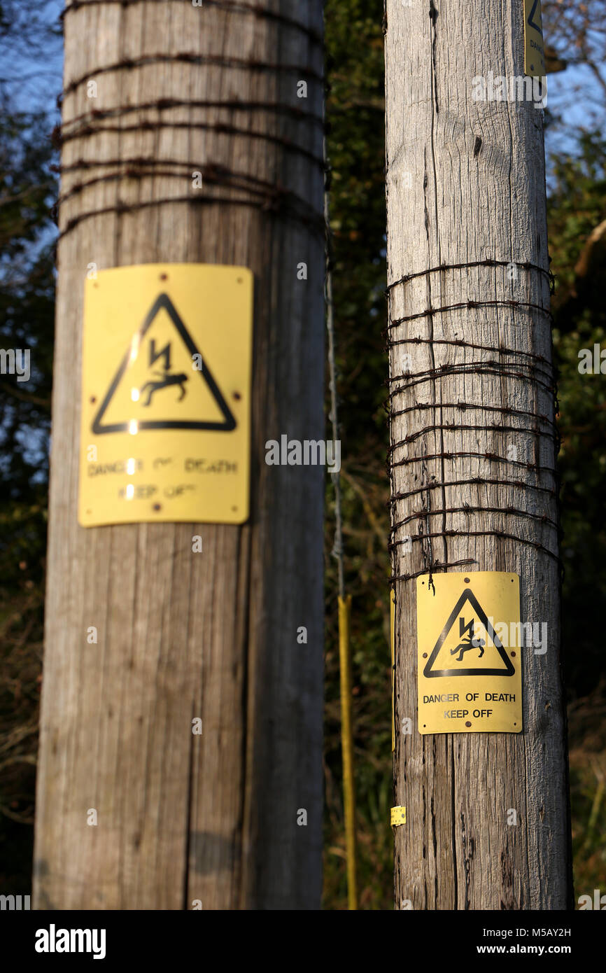 Electricity pylons with danger of death signs and barbed wire in ...