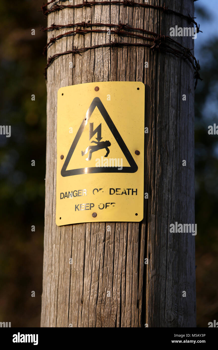 Electricity pylons with danger of death signs and barbed wire in ...